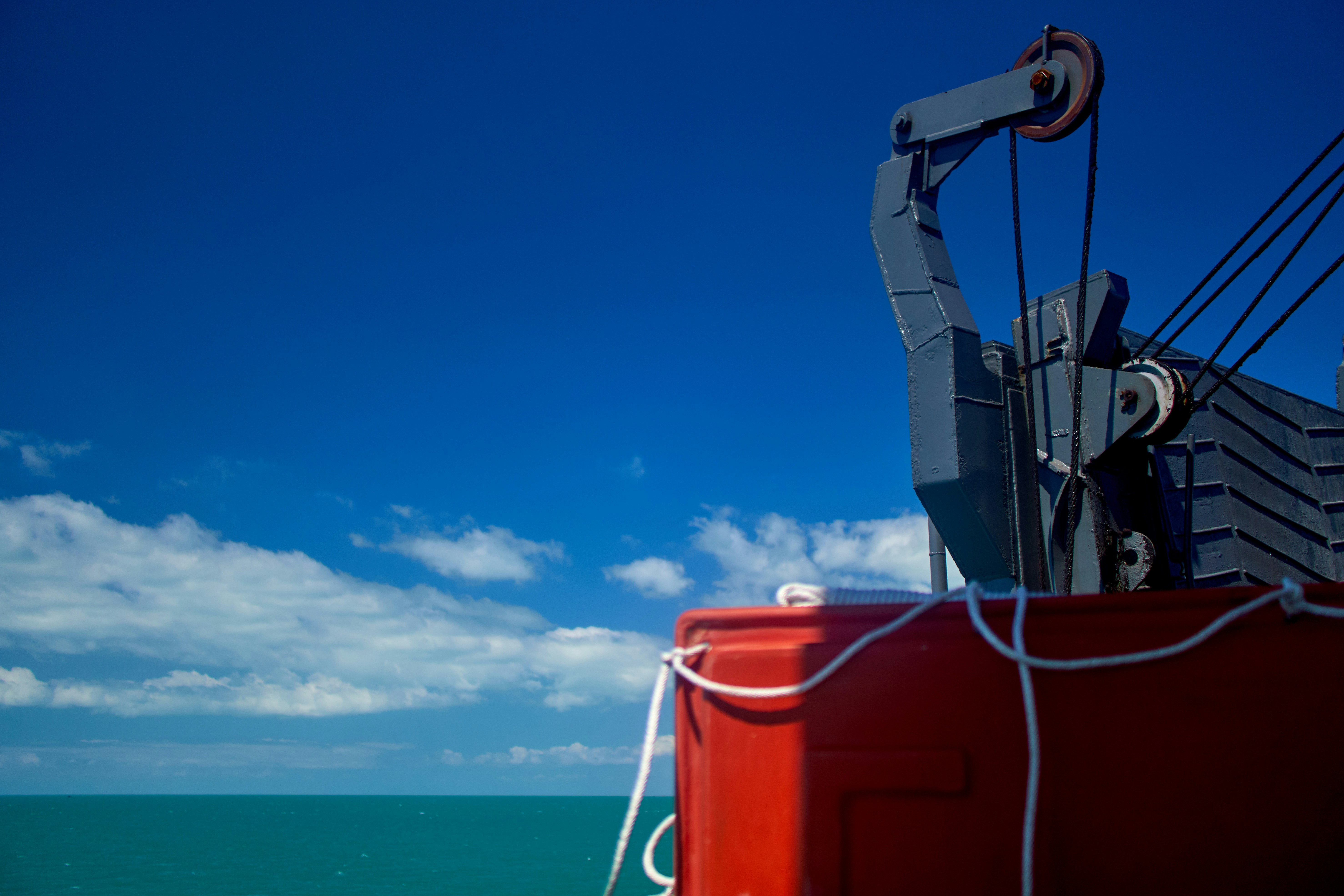Red and black power boat on sea under blue sky during daytime photo ...