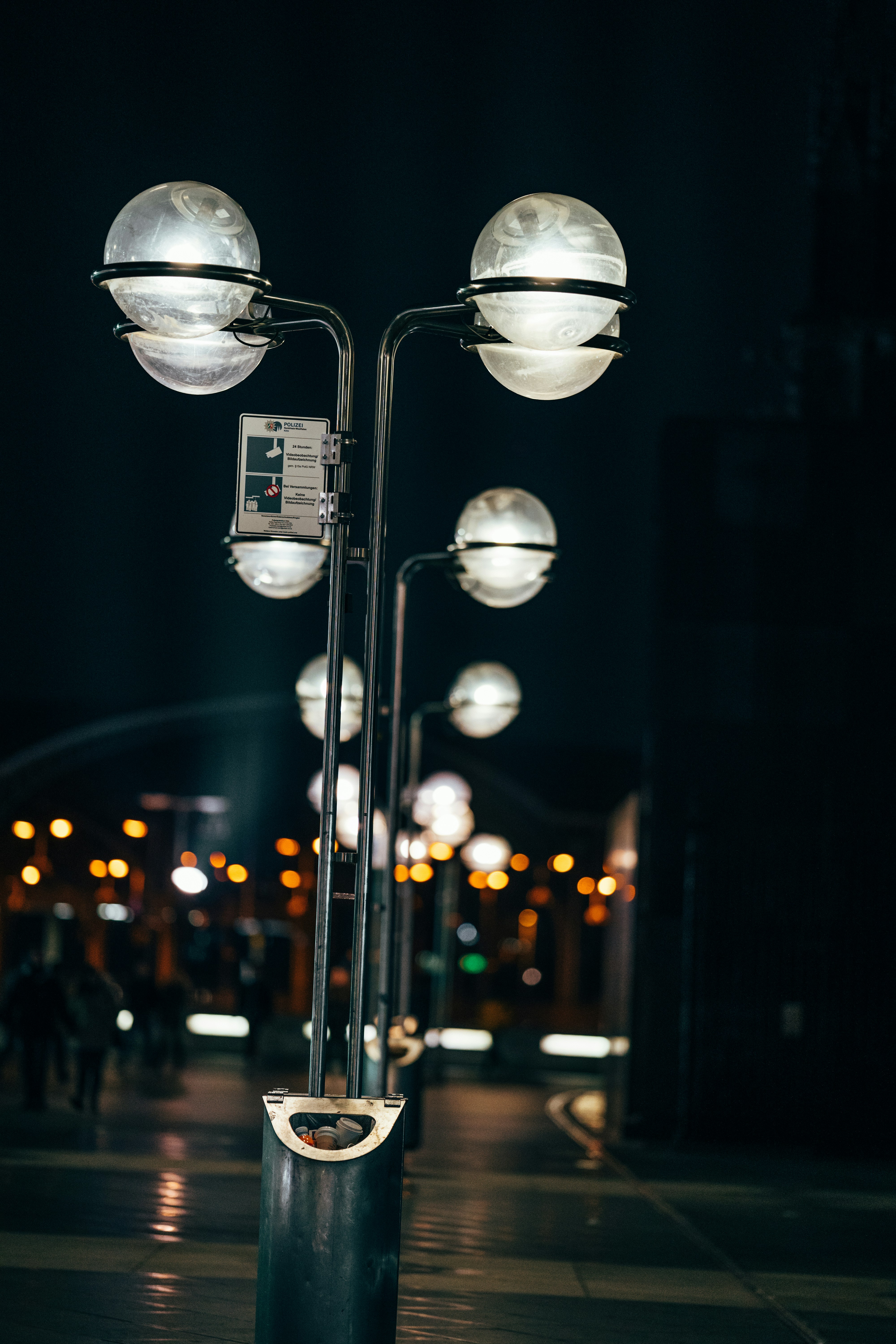 Orbed Streetlamps Line a Quiet Night Corridor