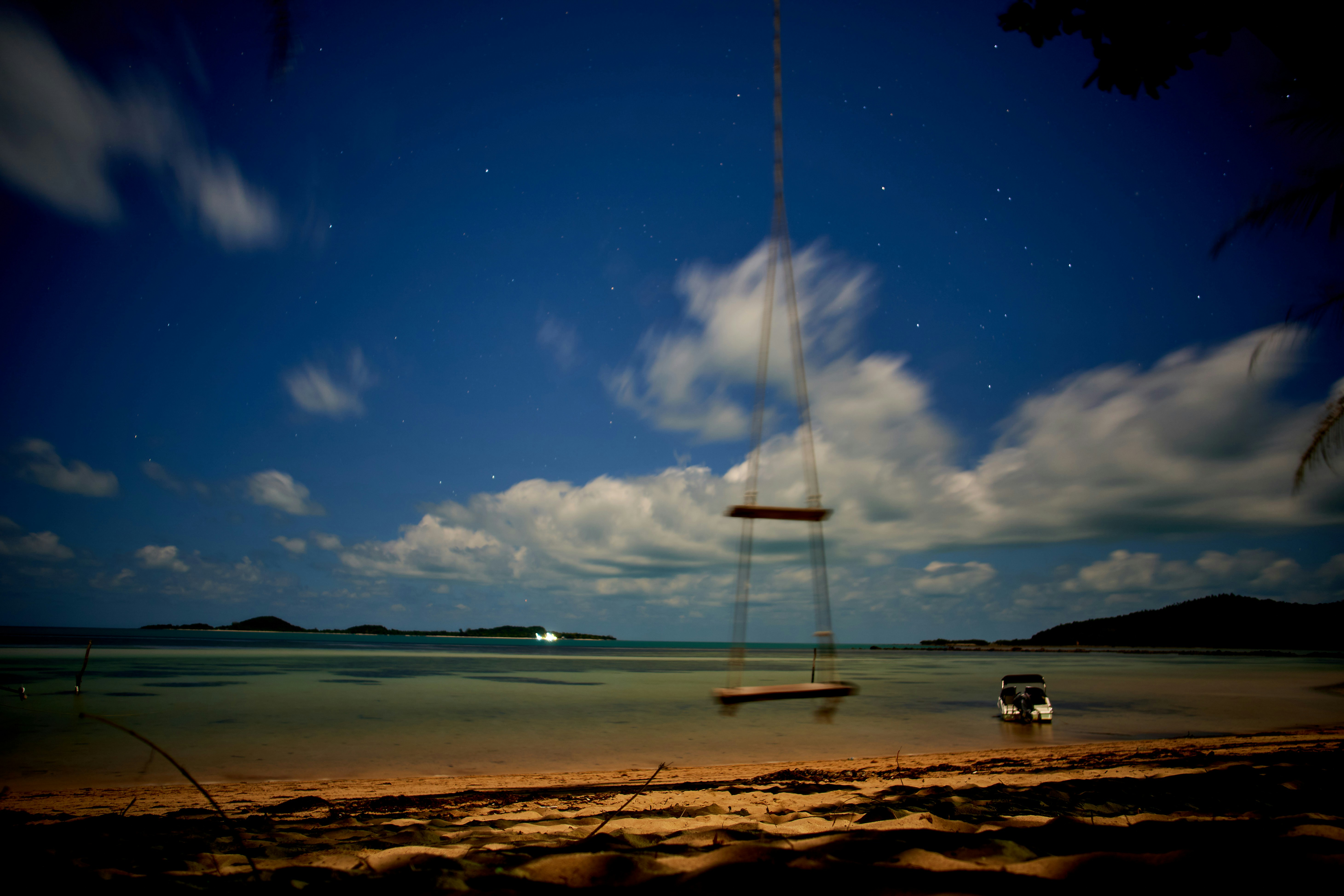 Palm and Boat at night a tropical beach summer vacation in Thailand