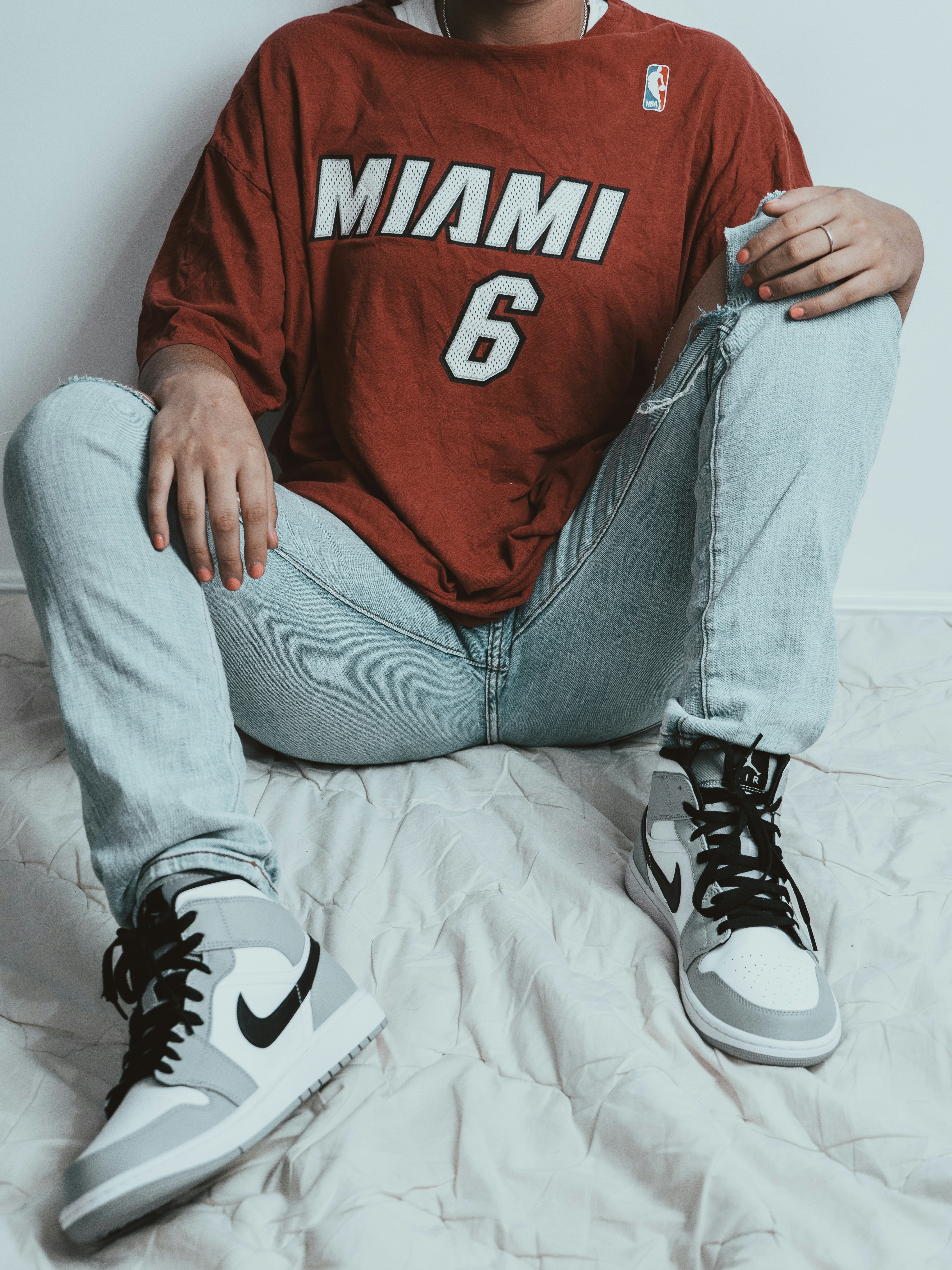Red Miami Tee, Light Jeans, and Quiet Sneakers: A Bedroom Portrait
