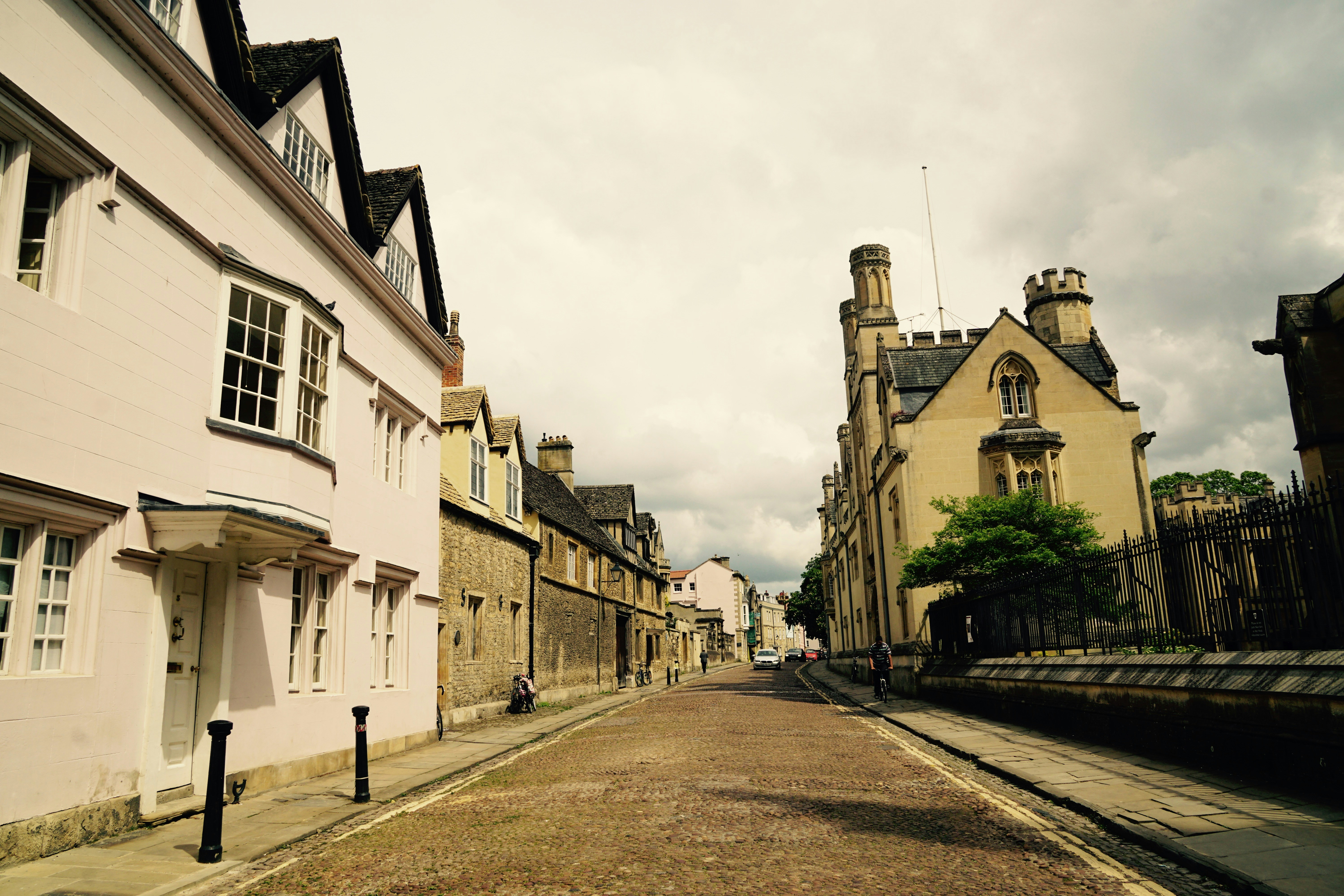 Charming cobblestone street flanked by historic buildings under a cloudy sky, inviting exploration and discovery.