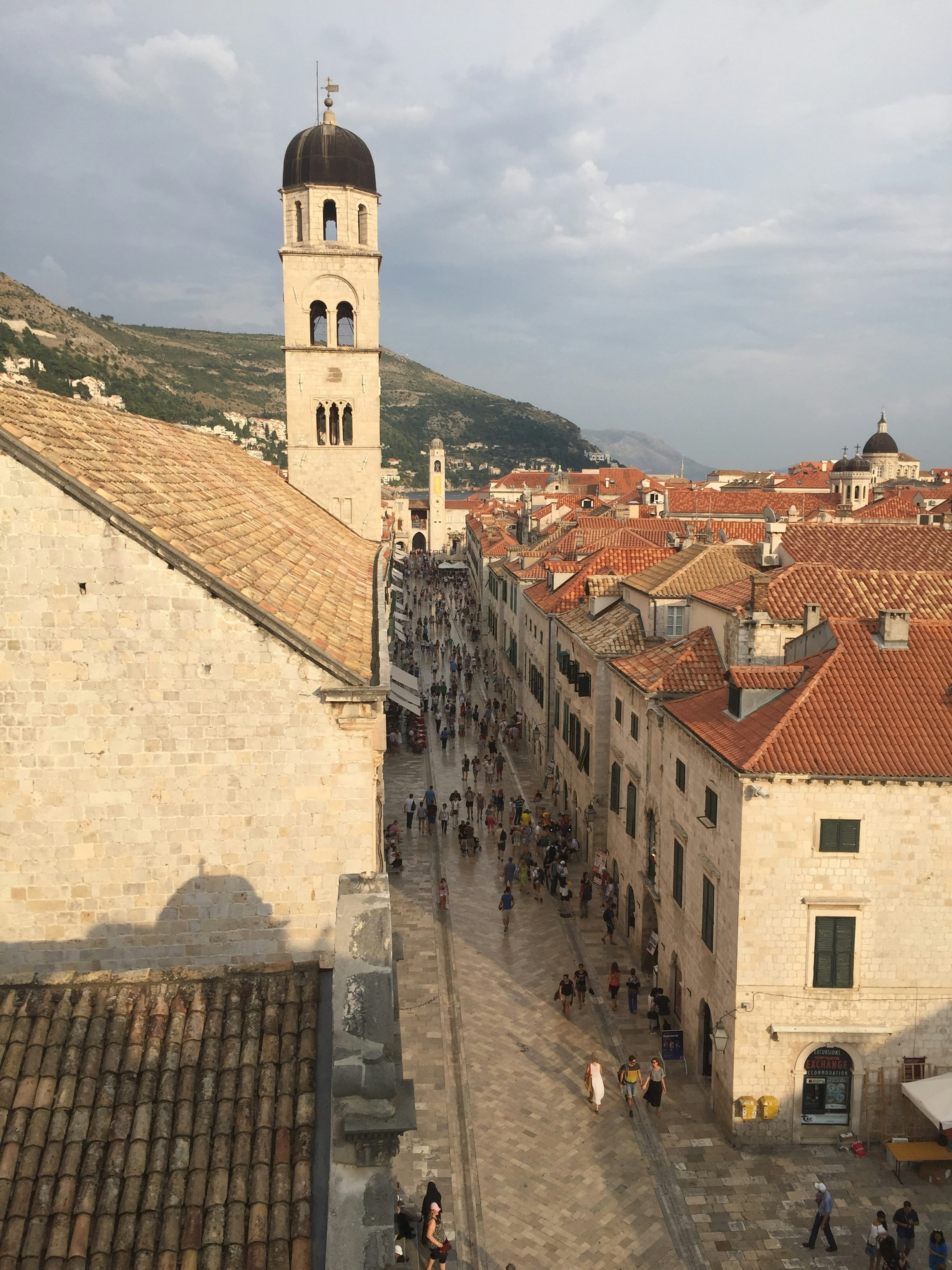 Stone Avenue Toward the Bell Tower: A Corridor of Terracotta Rooftops