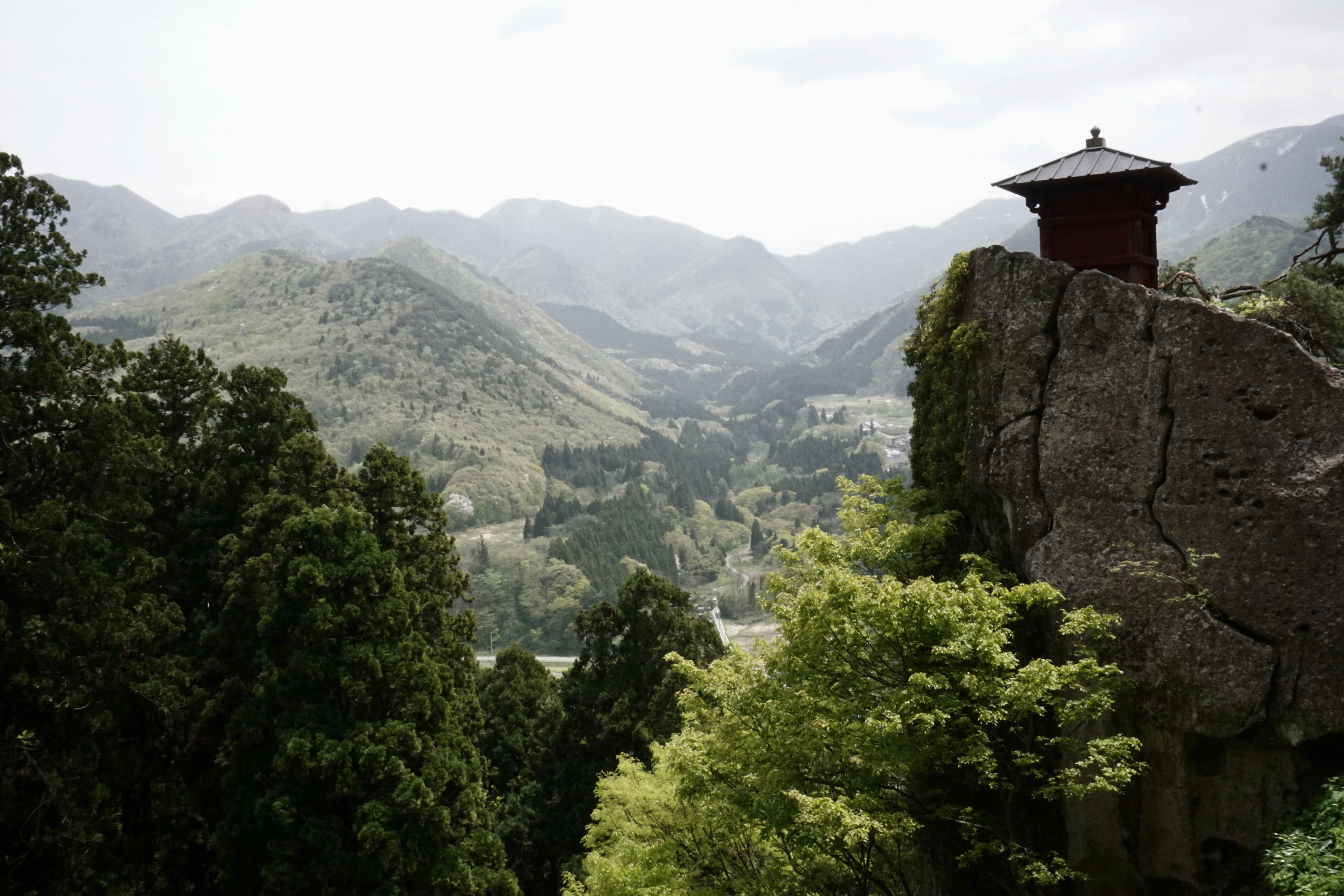 Cliffside Shrine: A Red Roof Crowns the Edge Over a Verdant Valley
