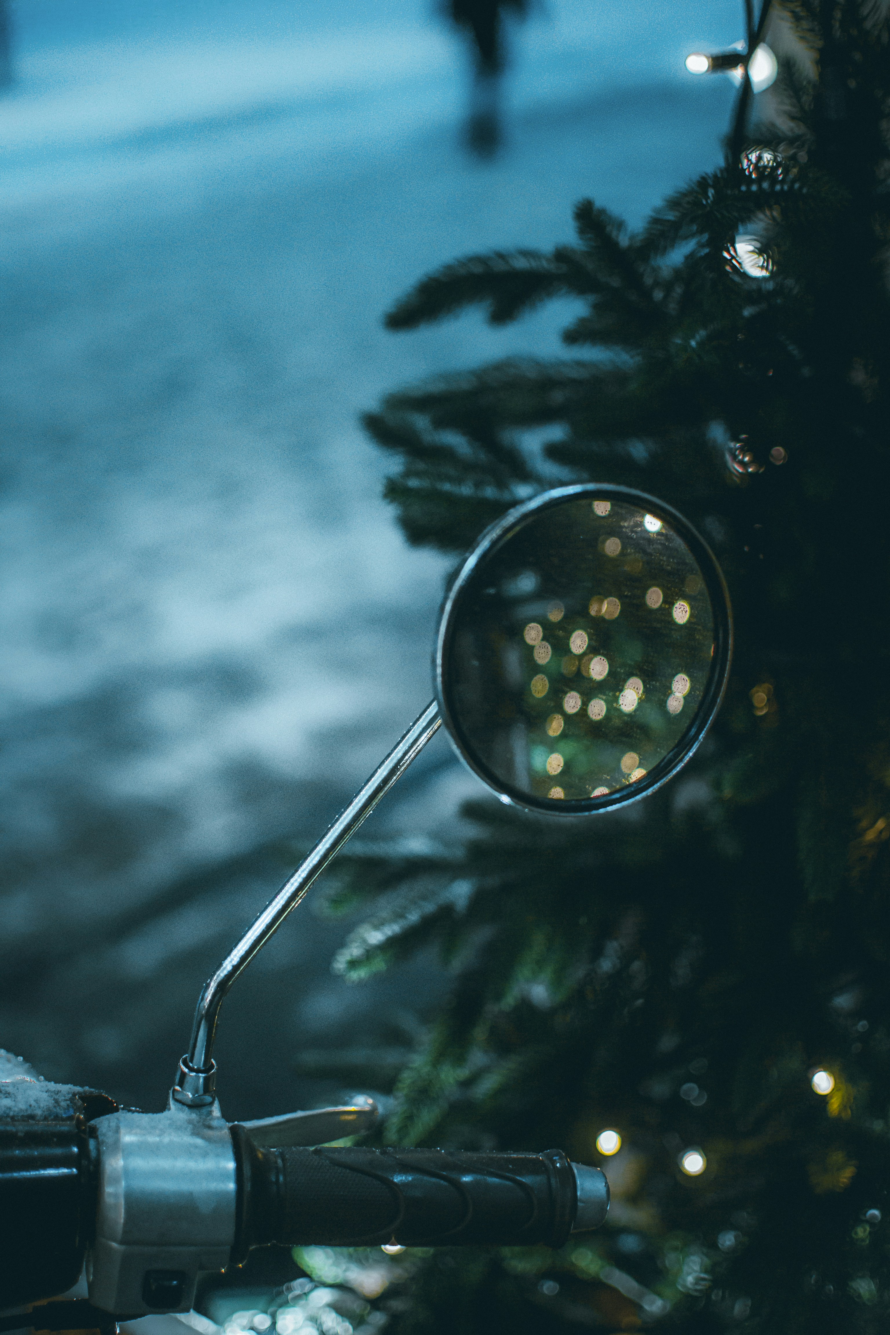 Blue Hour Chrome: A Motorcycle Mirror Framed by Quiet Lights