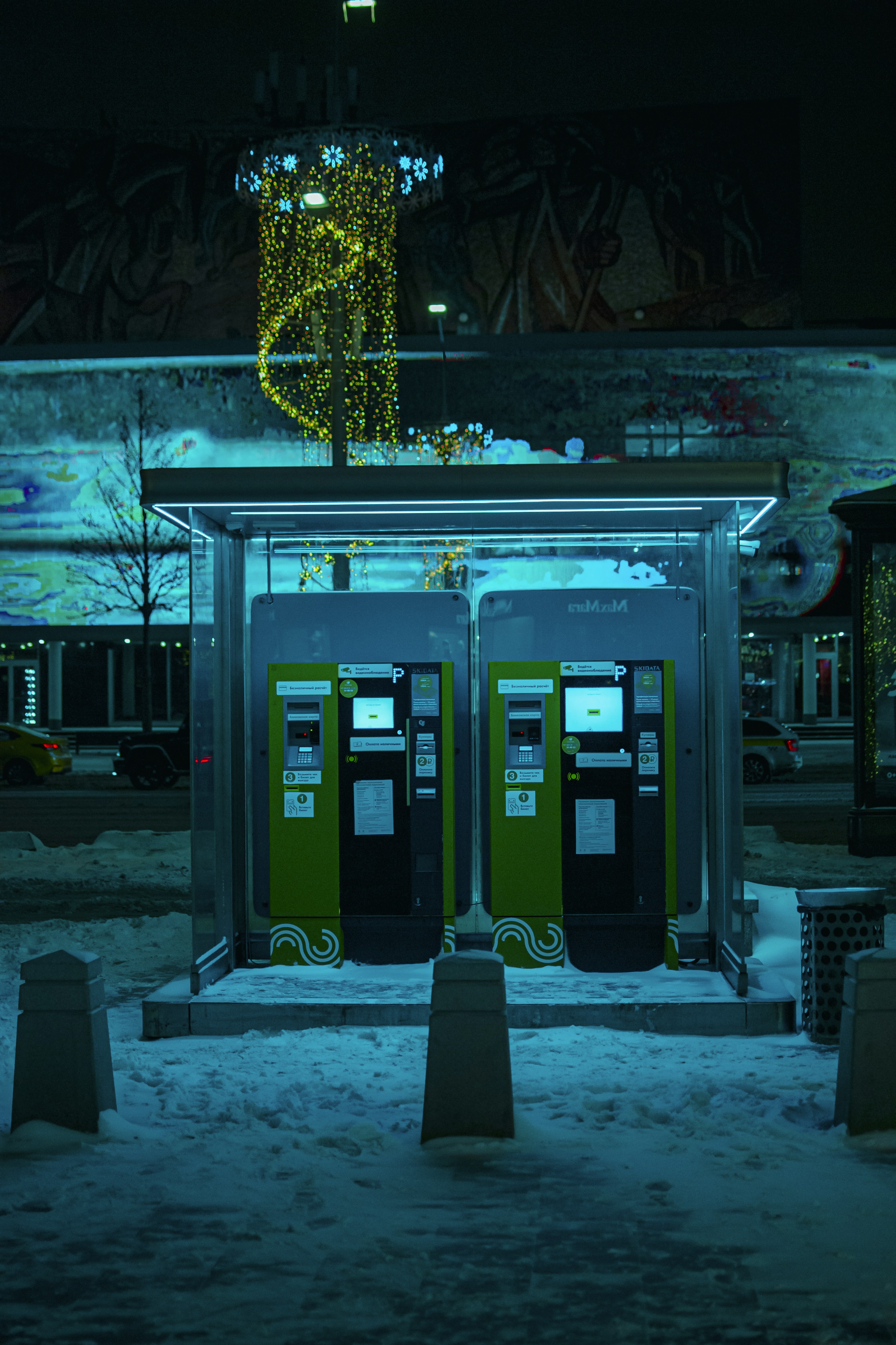 Neon-green Pay Terminals Under Blue Hour Glow in a Snow-Covered Square
