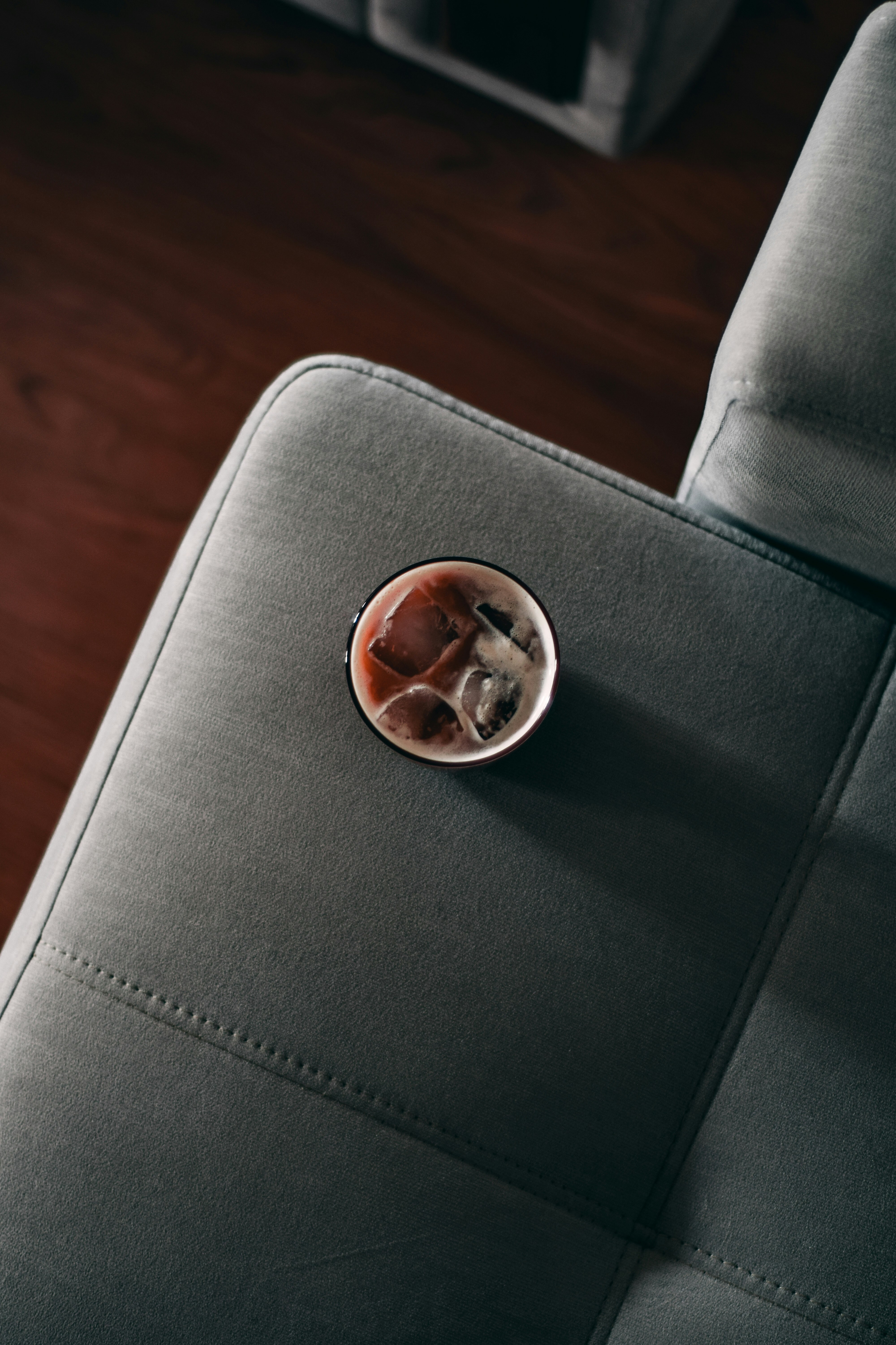Ice in a Tiny Metal Cup Resting on a Quiet Gray Lounge Chair