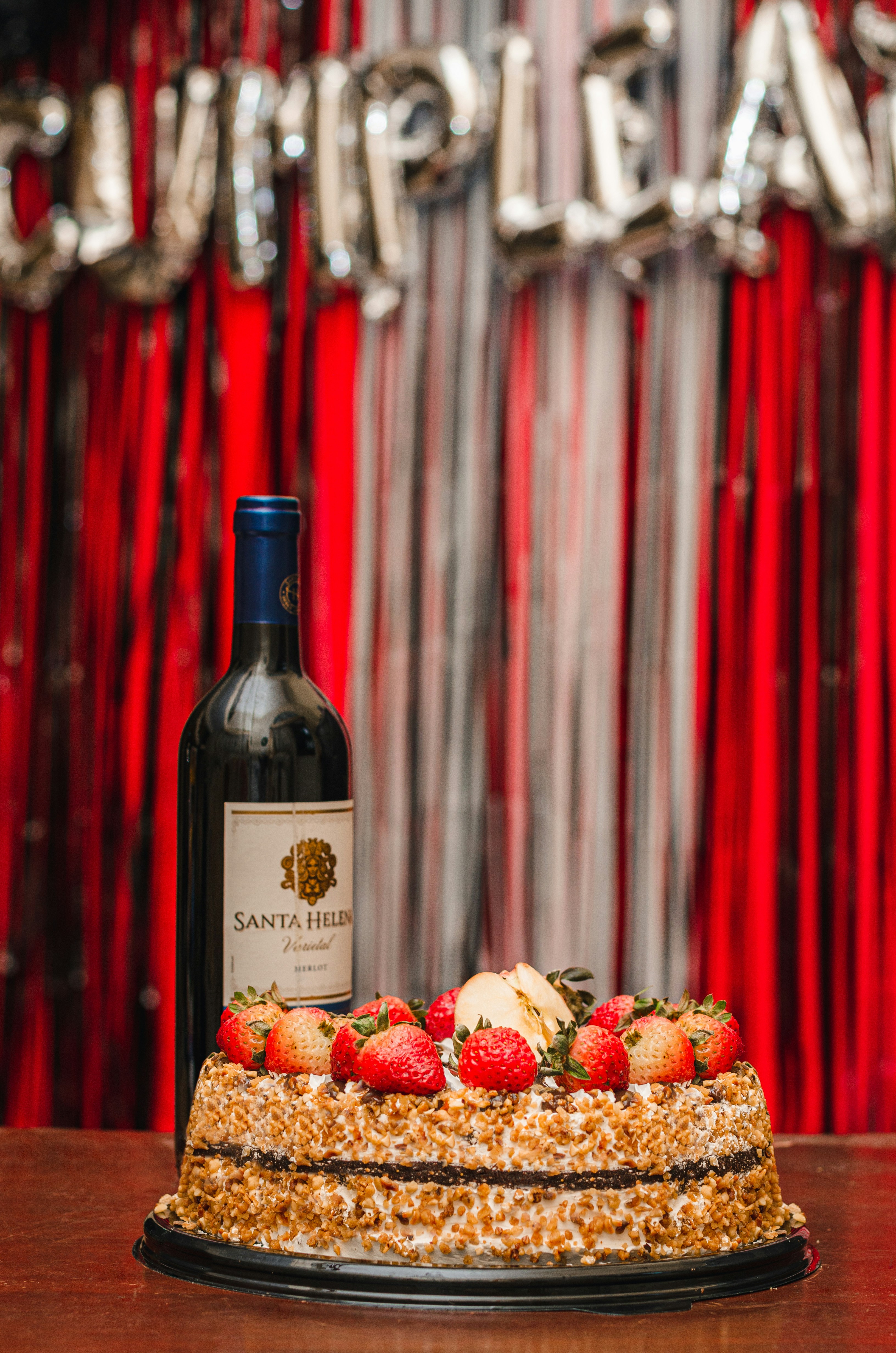 Blissful Slice: Chocolate-Nut Cake with Fresh Berries and a Bottle of Red