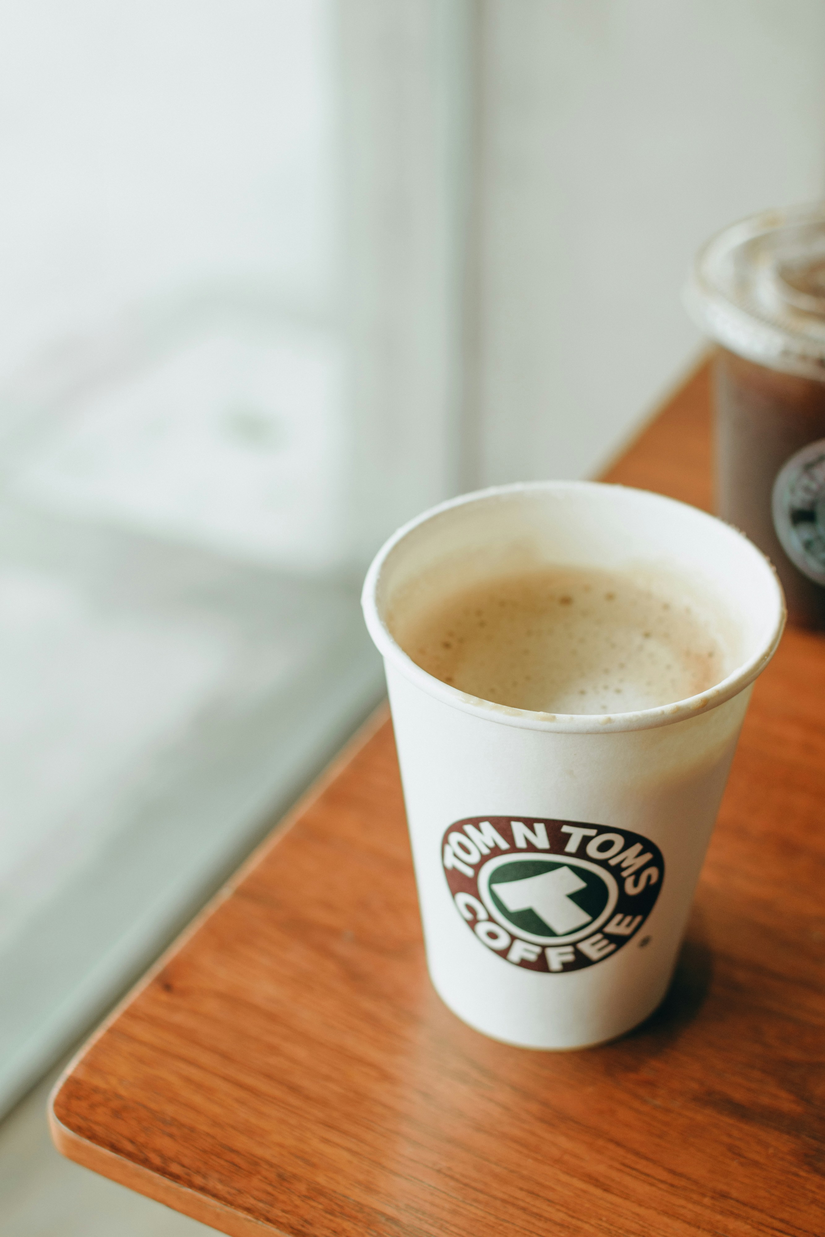 Steam Amid Warm Light: Coffee Cup at the Window Edge