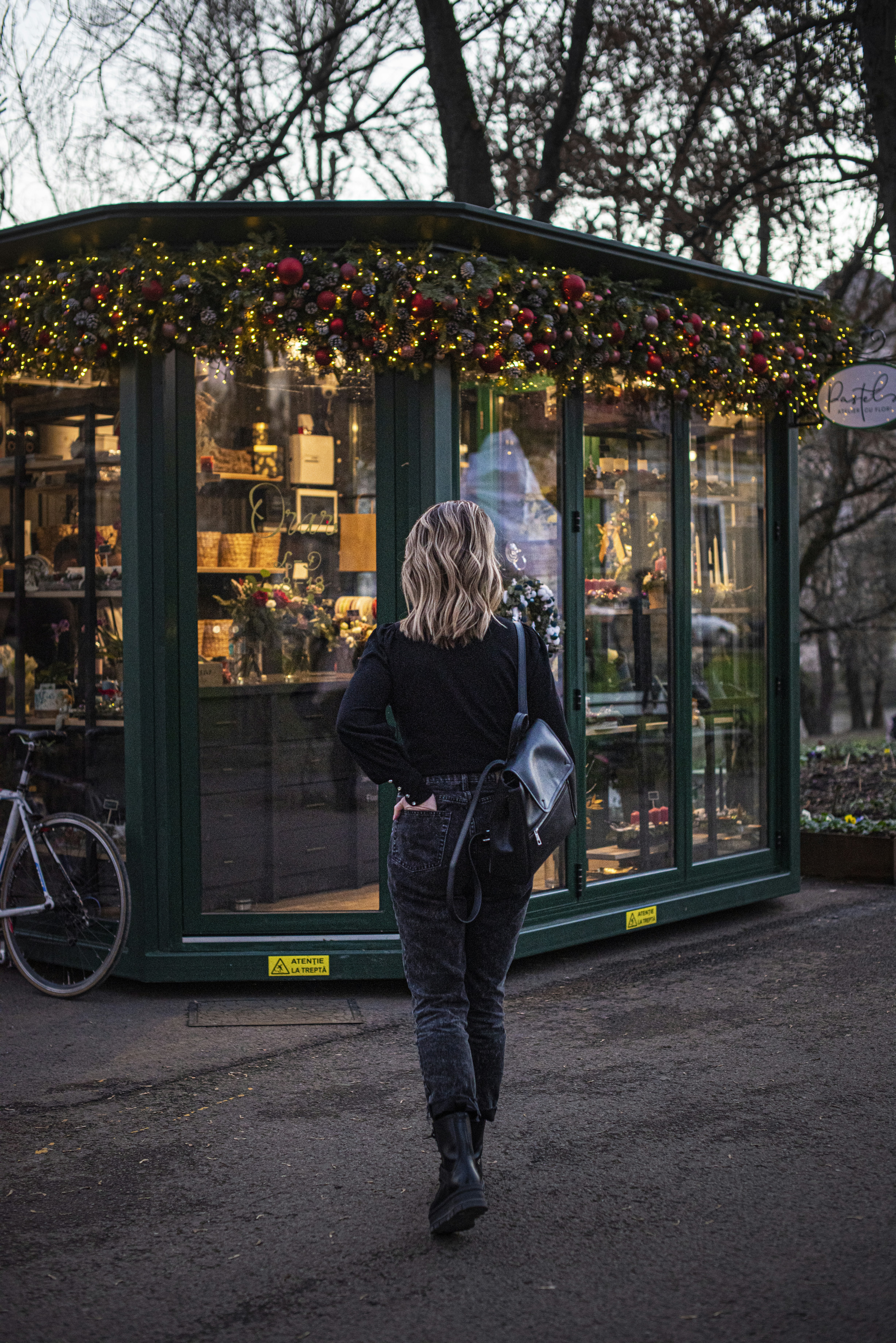 Back-turned Shopper Enveloped by Festive Storefront Glow