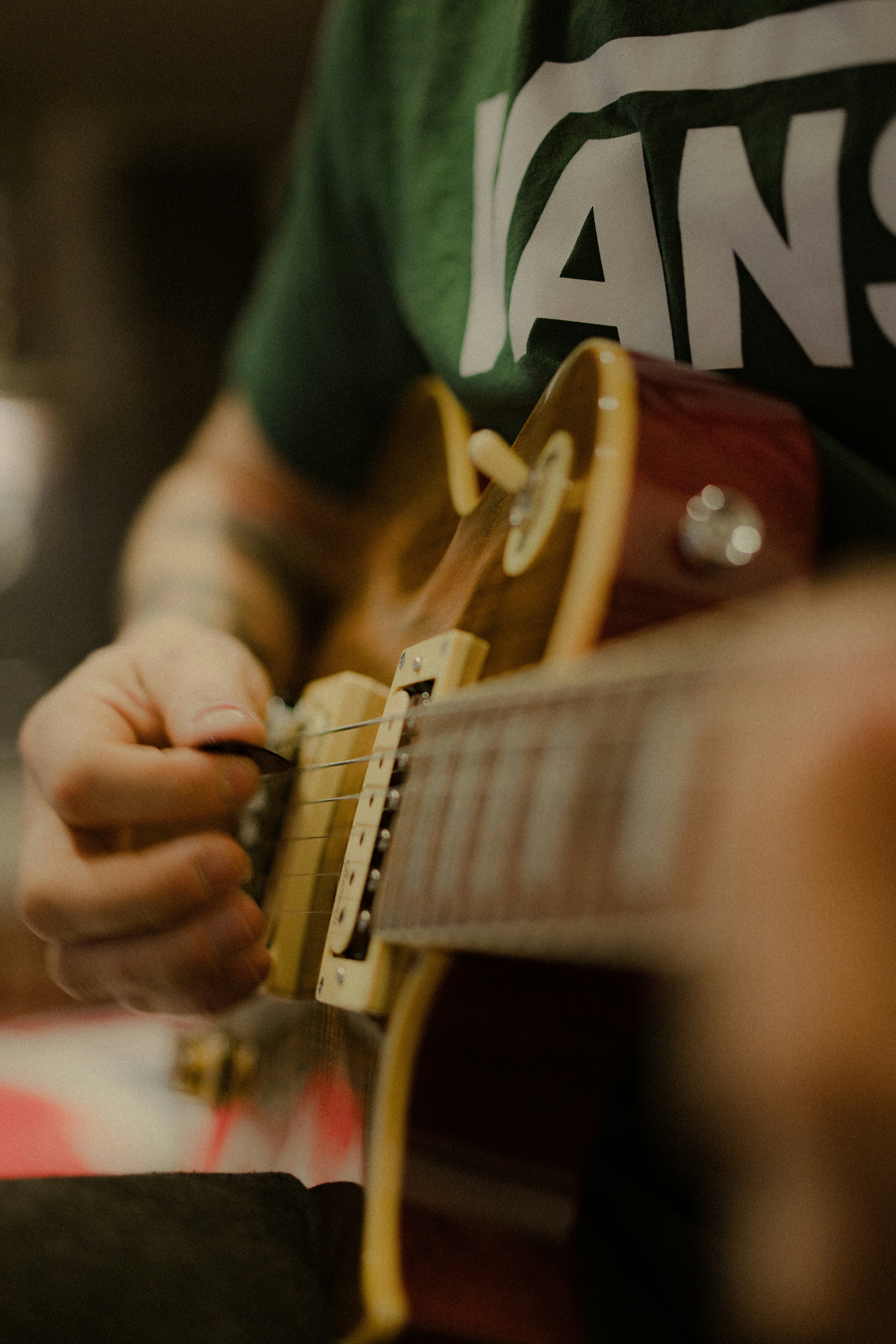 person playing brown and white electric guitar
