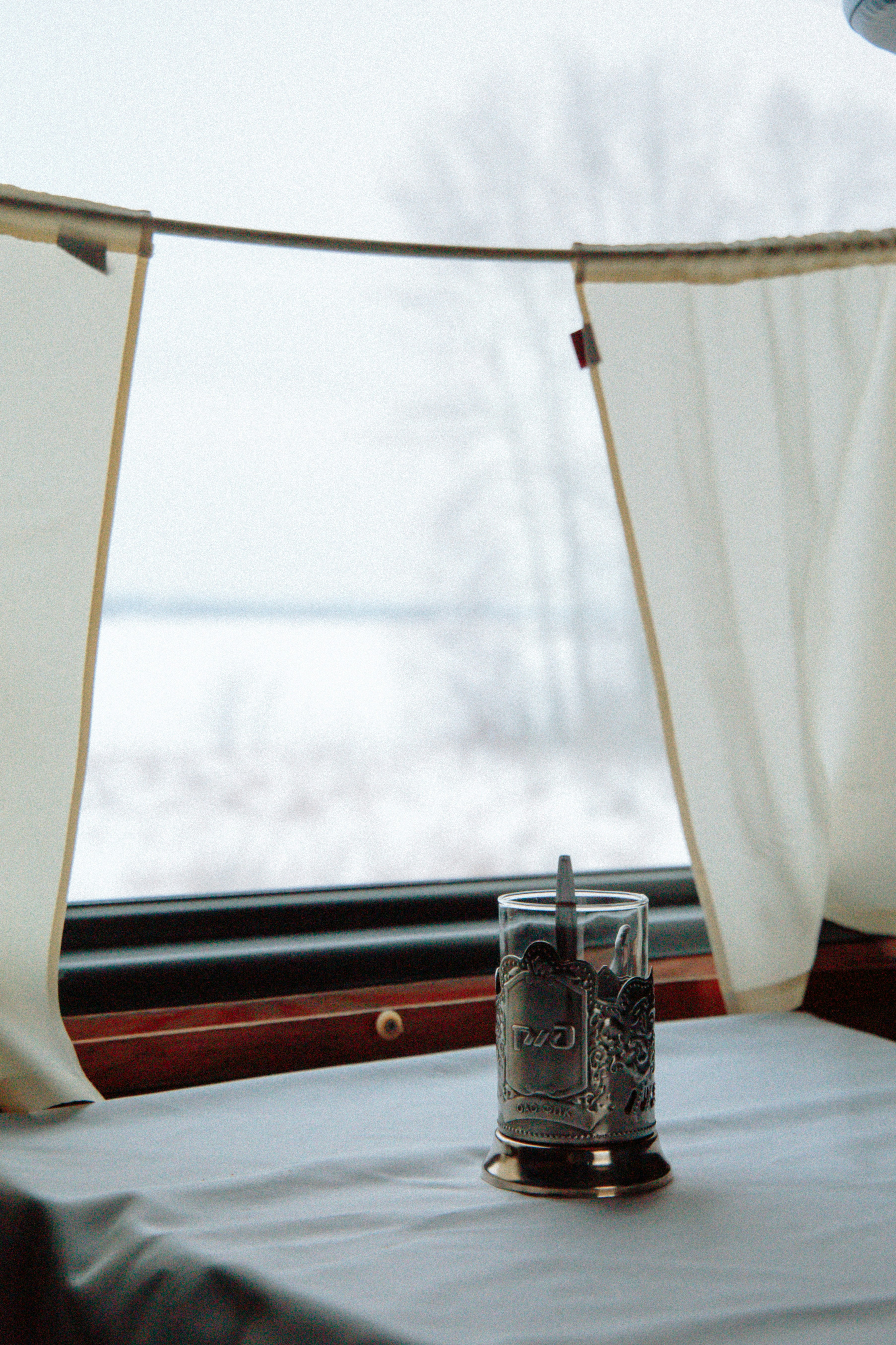 Curtains of Silence: A Candle on the Windowsill Backdrops Winter Light