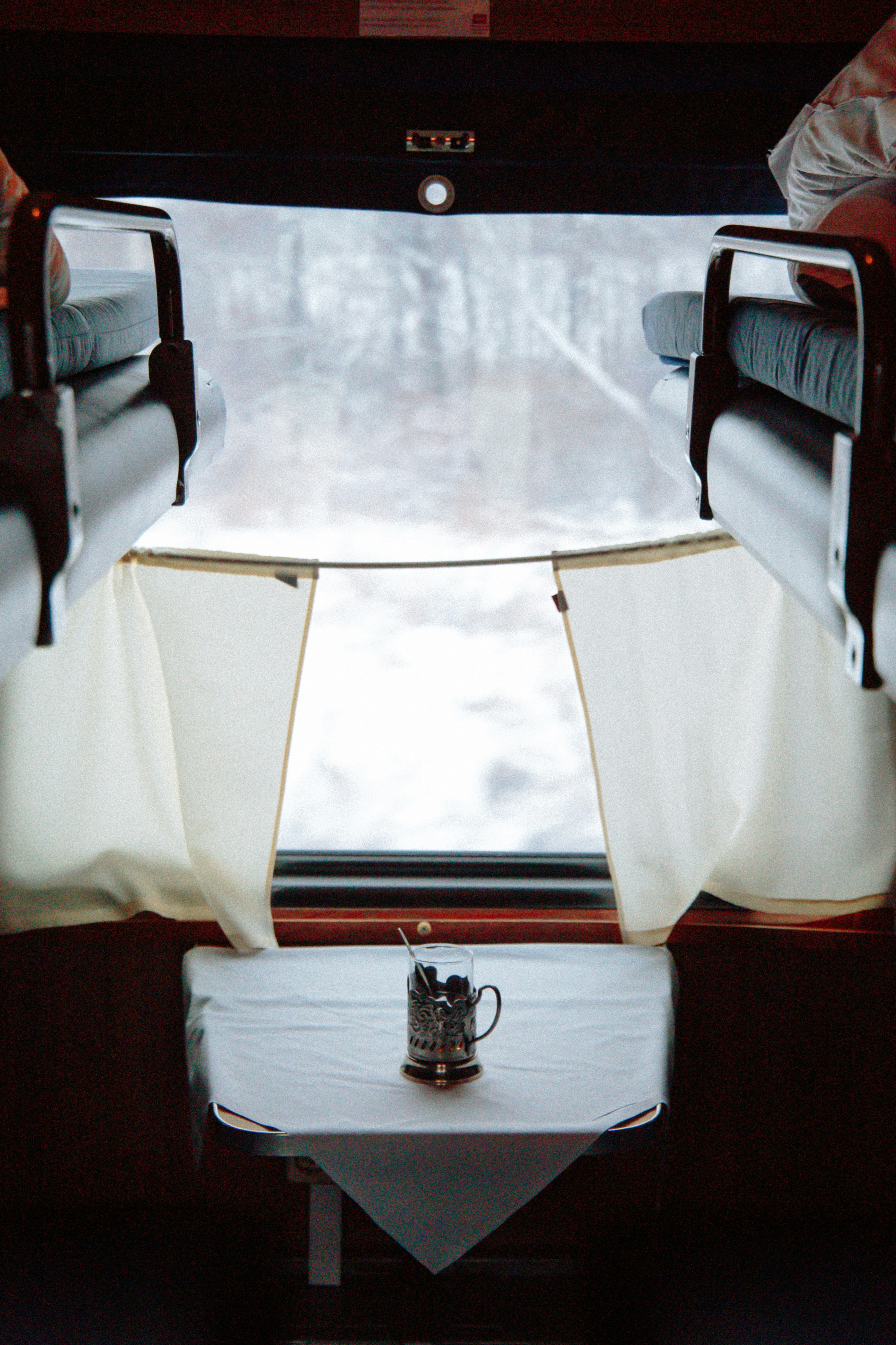 Central Fold: A Quiet Tableset Framed by Bus Seats and Open Curtain