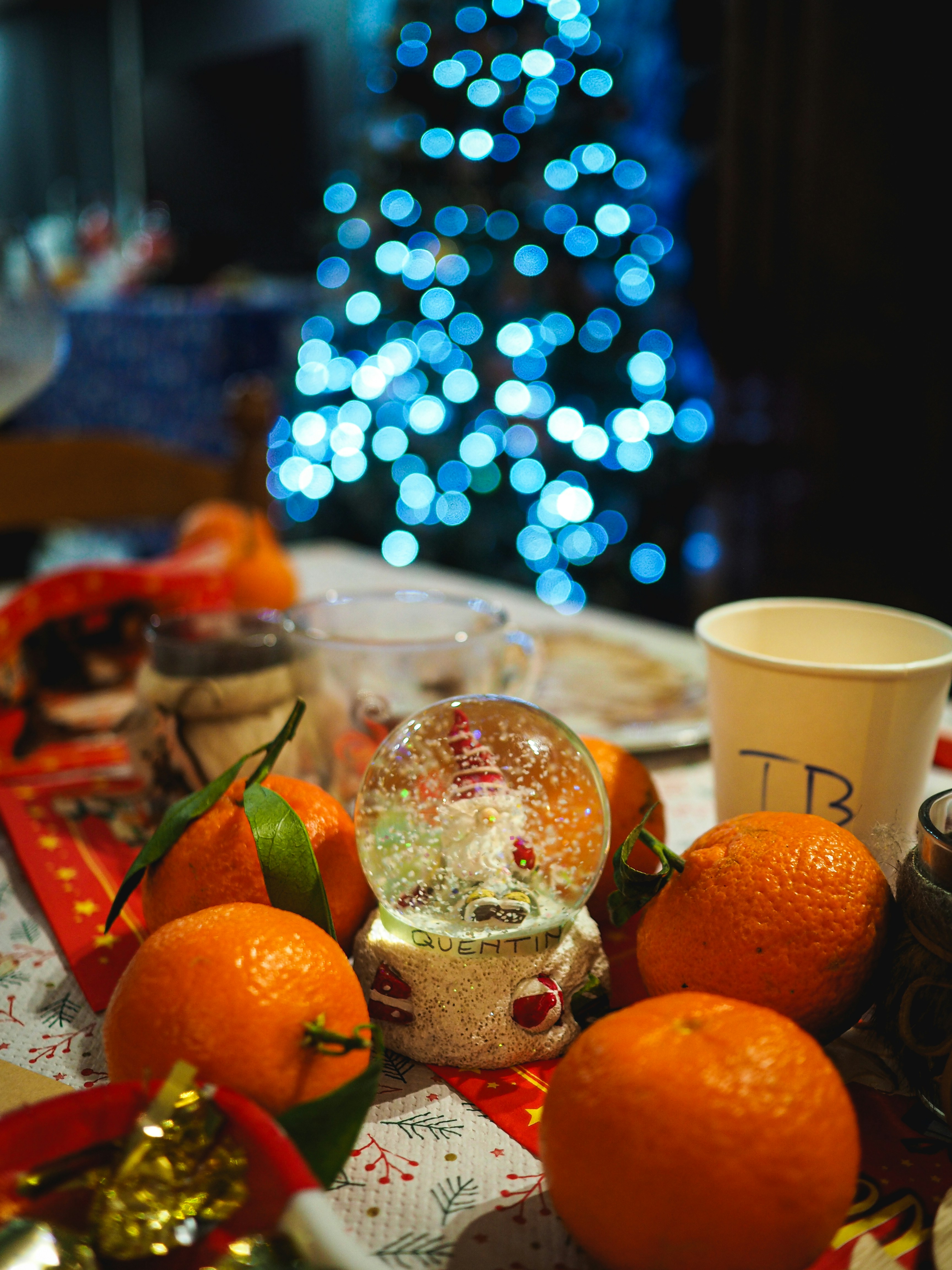Snow globe centerpiece under cobalt holiday glow among oranges