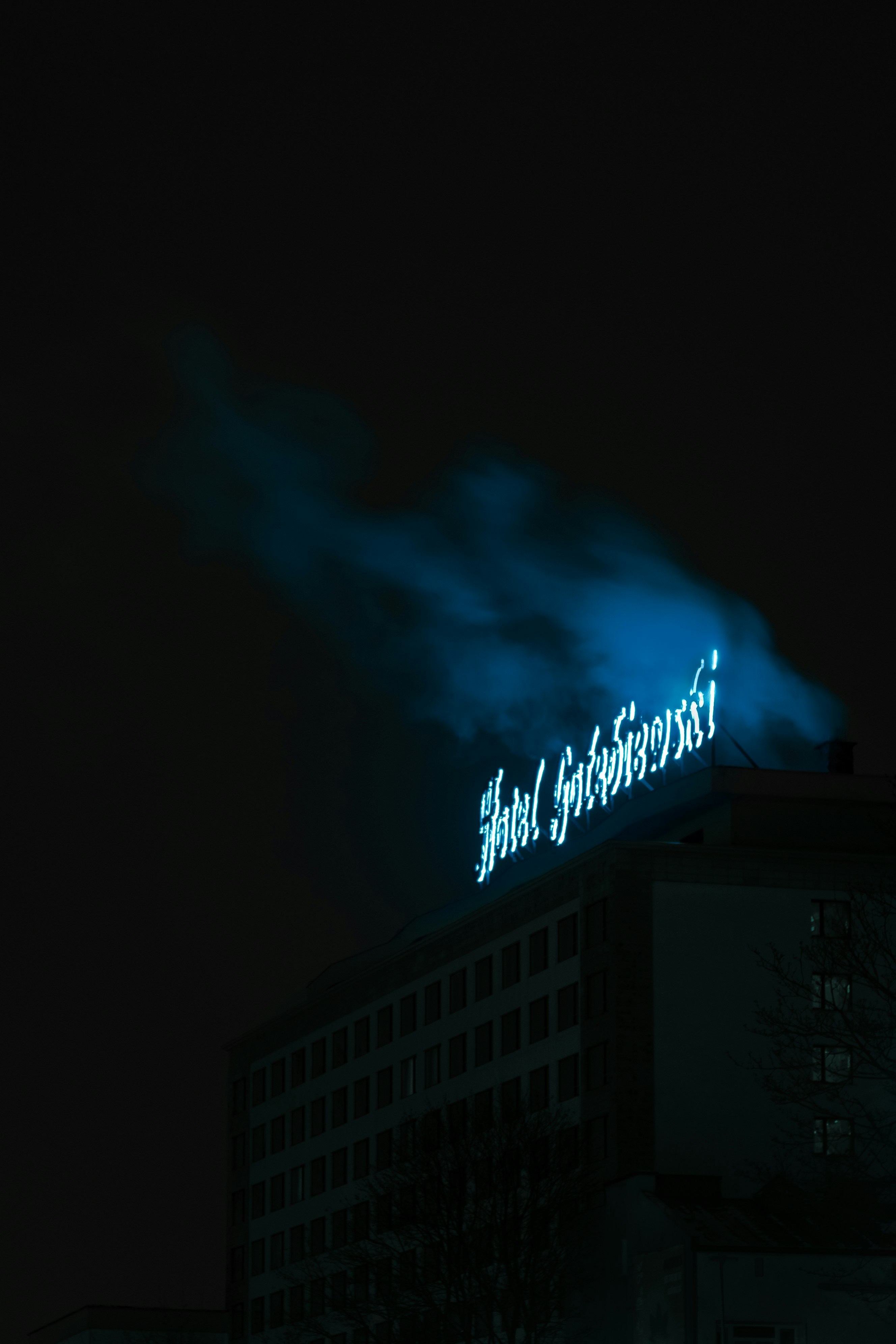a very tall building with a neon sign on top of it