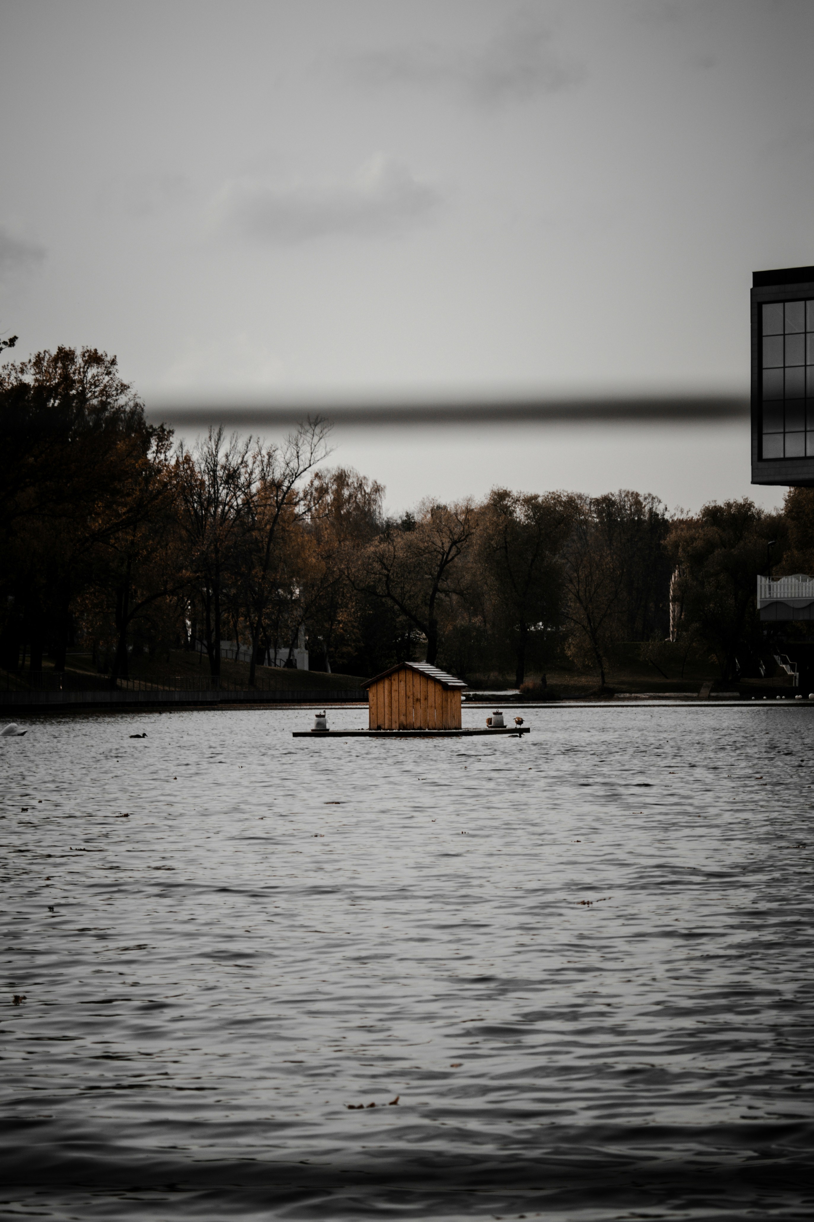 Drifted Boathouse on a Quiet Lake Under Autumn Light