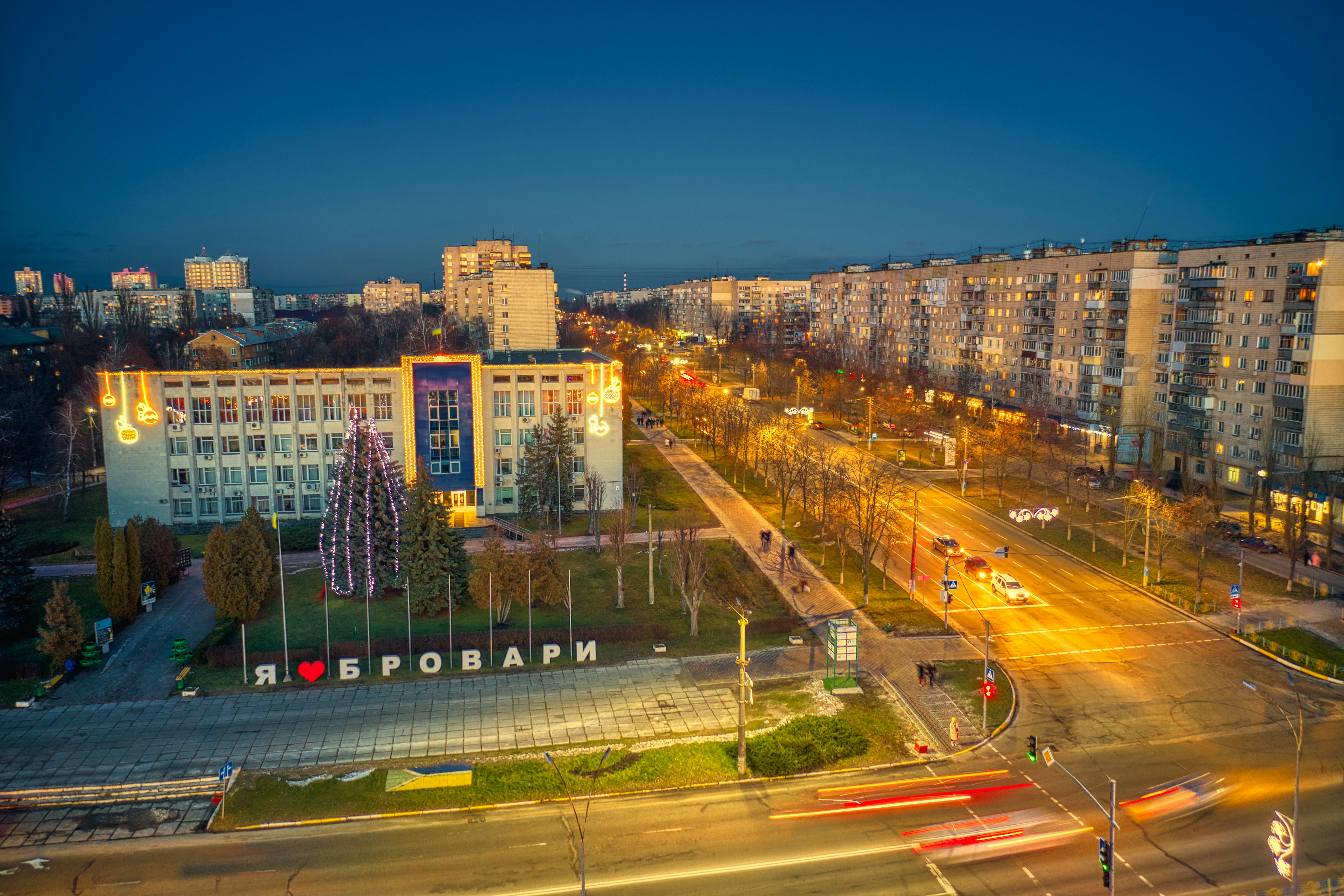 Twilight Over Brovary: Neon Sign and Velvet Streets from Above