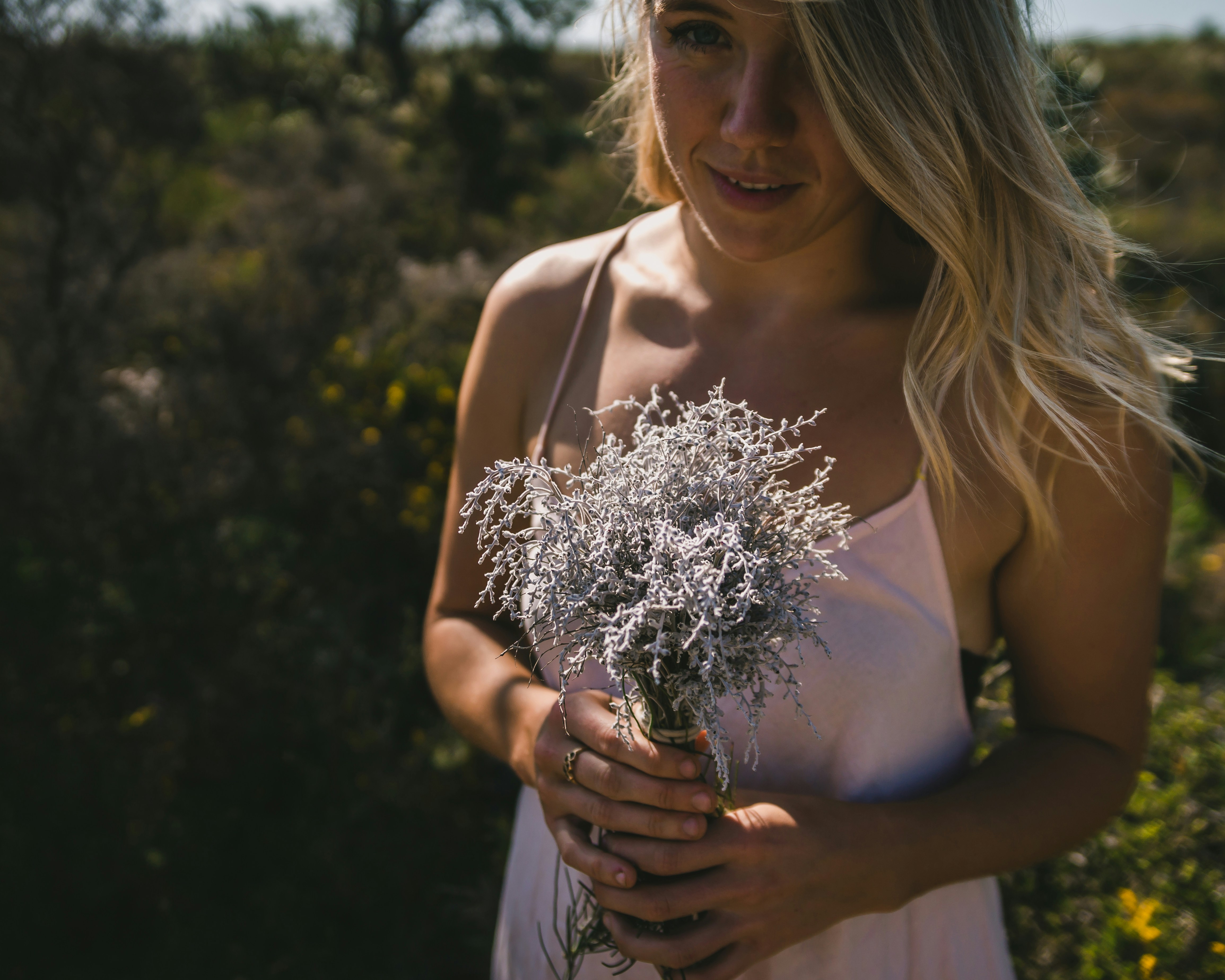 Woman in white tank top holding white and pink flowers photo – Free ...
