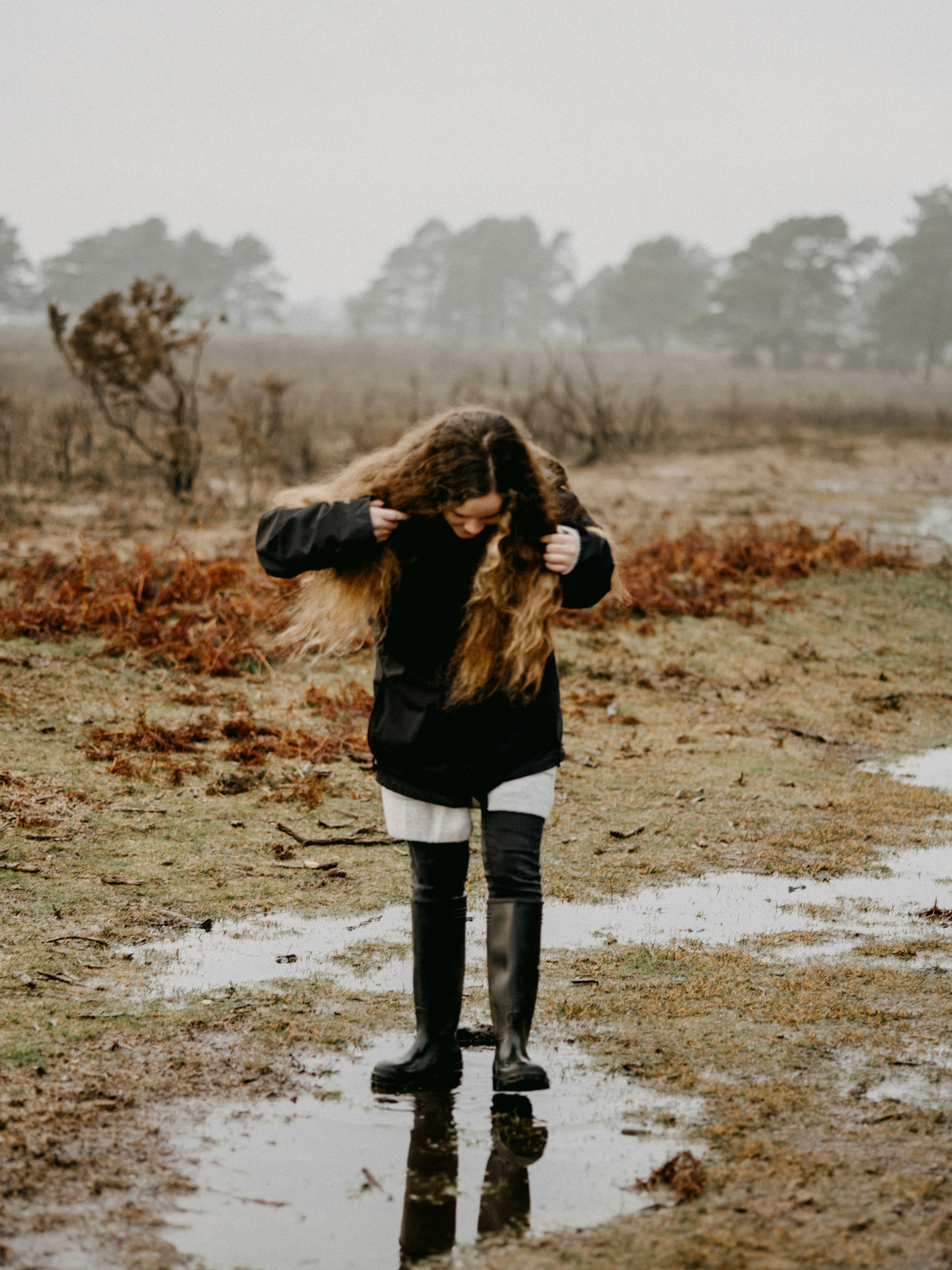 Fur-Hooded Wanderer in a Rain-Slick Field