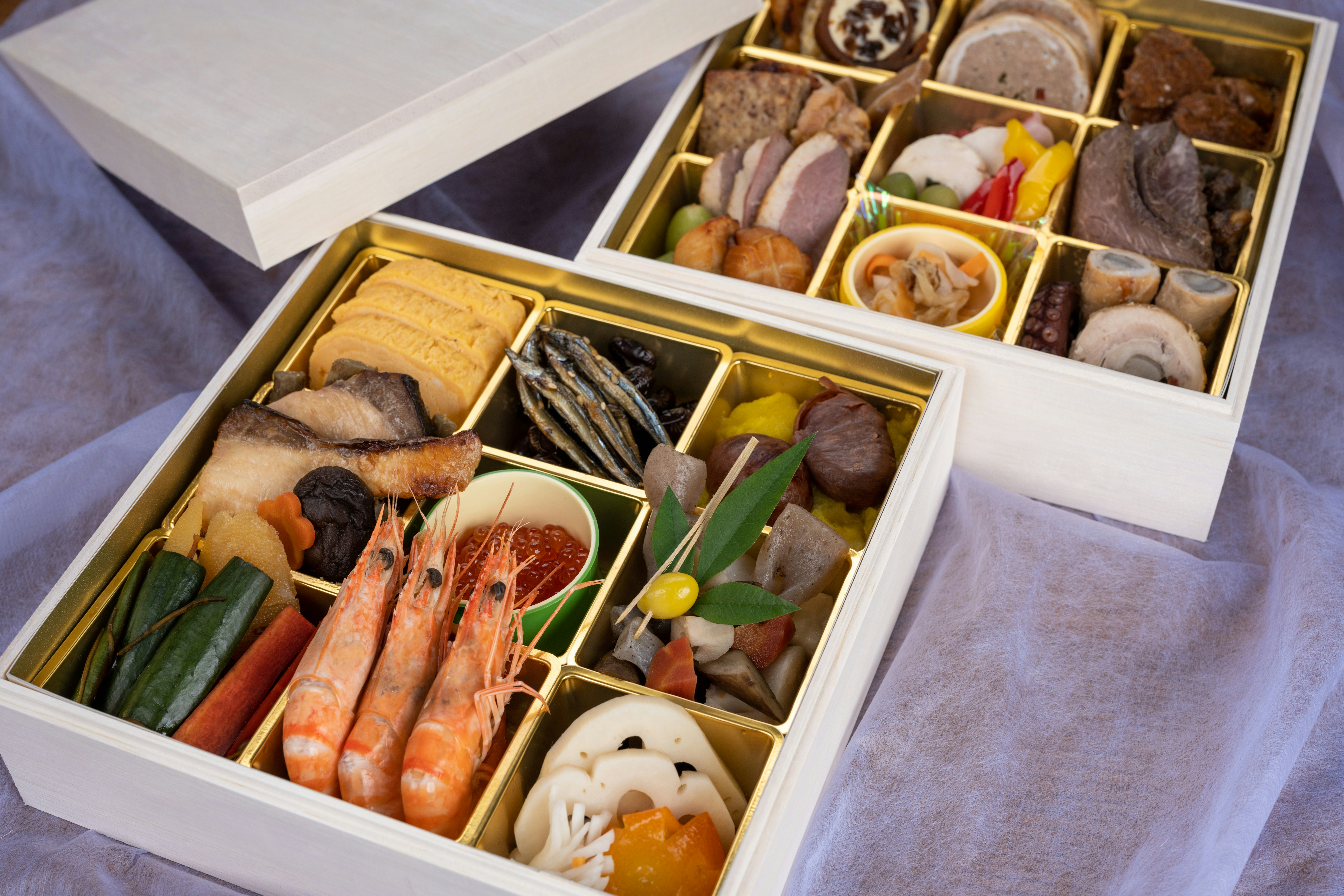 Traditional Japanese osechi ryori presented in elegant boxes, showcasing a variety of colorful dishes and ingredients. Each compartment is filled with meticulously prepared items for festive occasions.