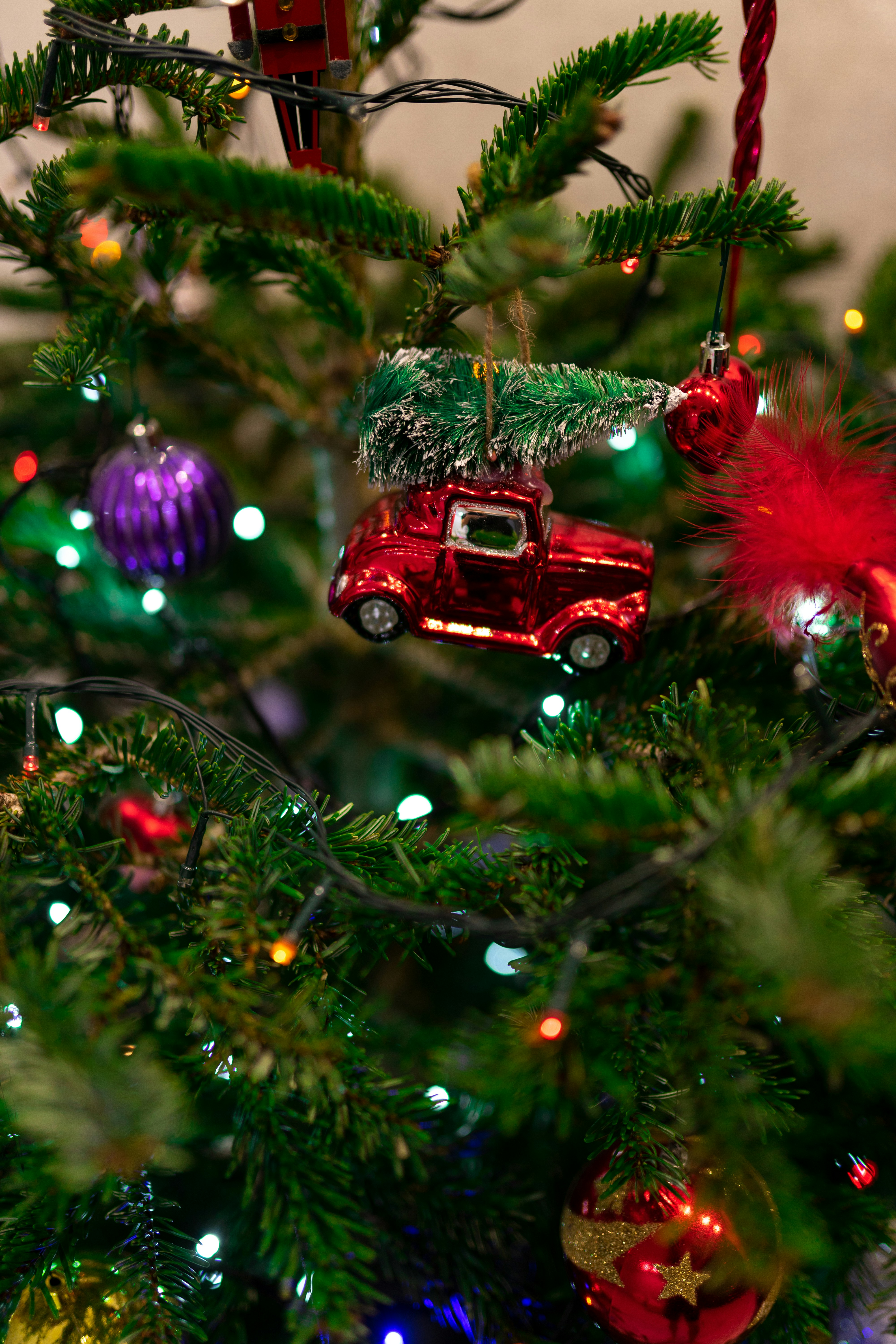 Red toy truck ornament weaving through Christmas-tree glow