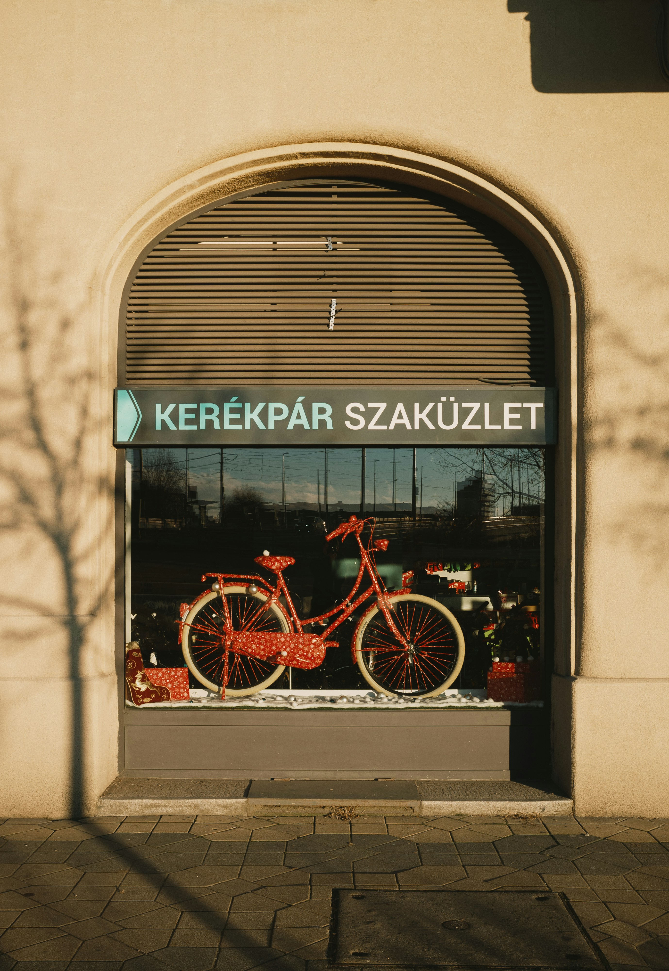 Crimson City Bicycle Framed by a Curved Shopfront