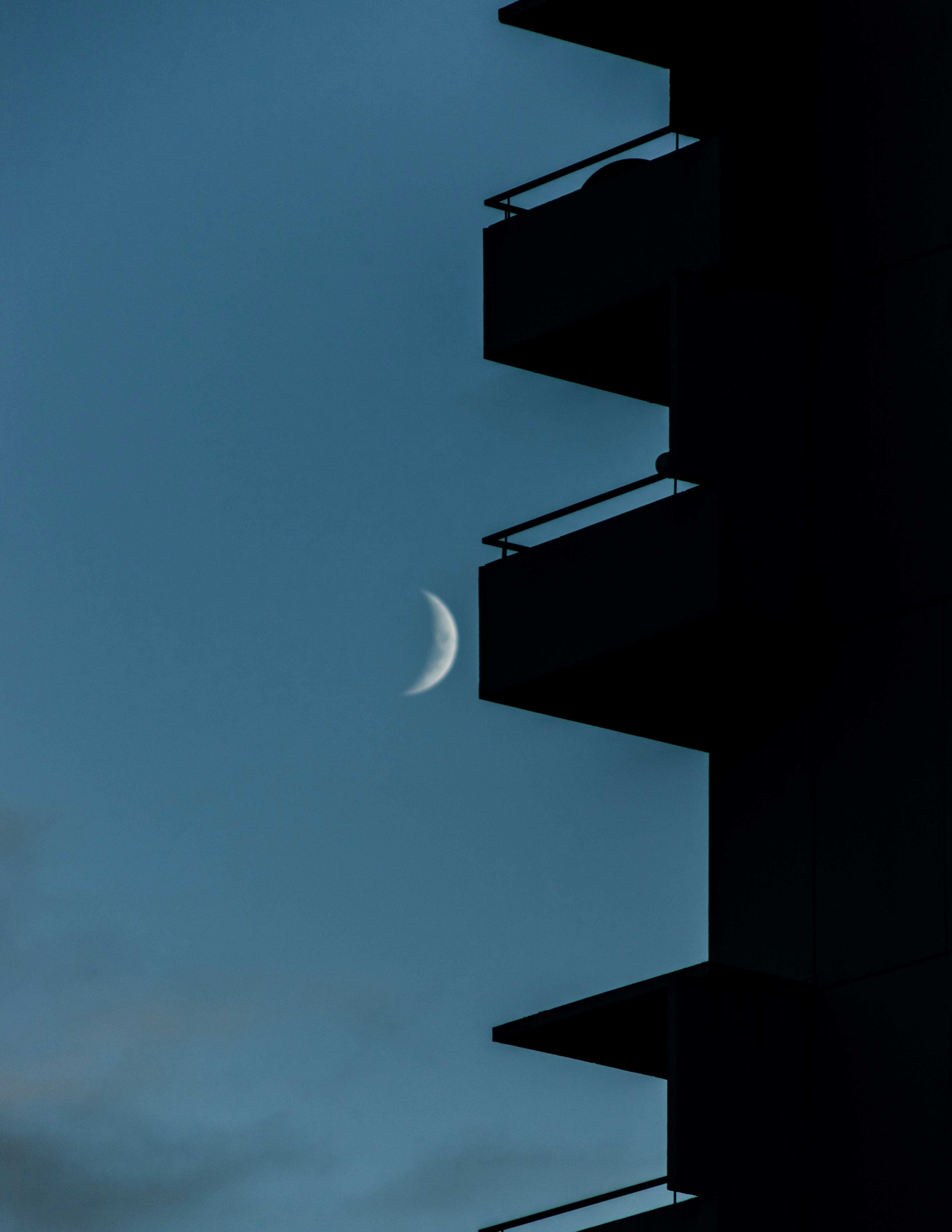 Crescent Moon Between Night-Born Balcony Silhouettes