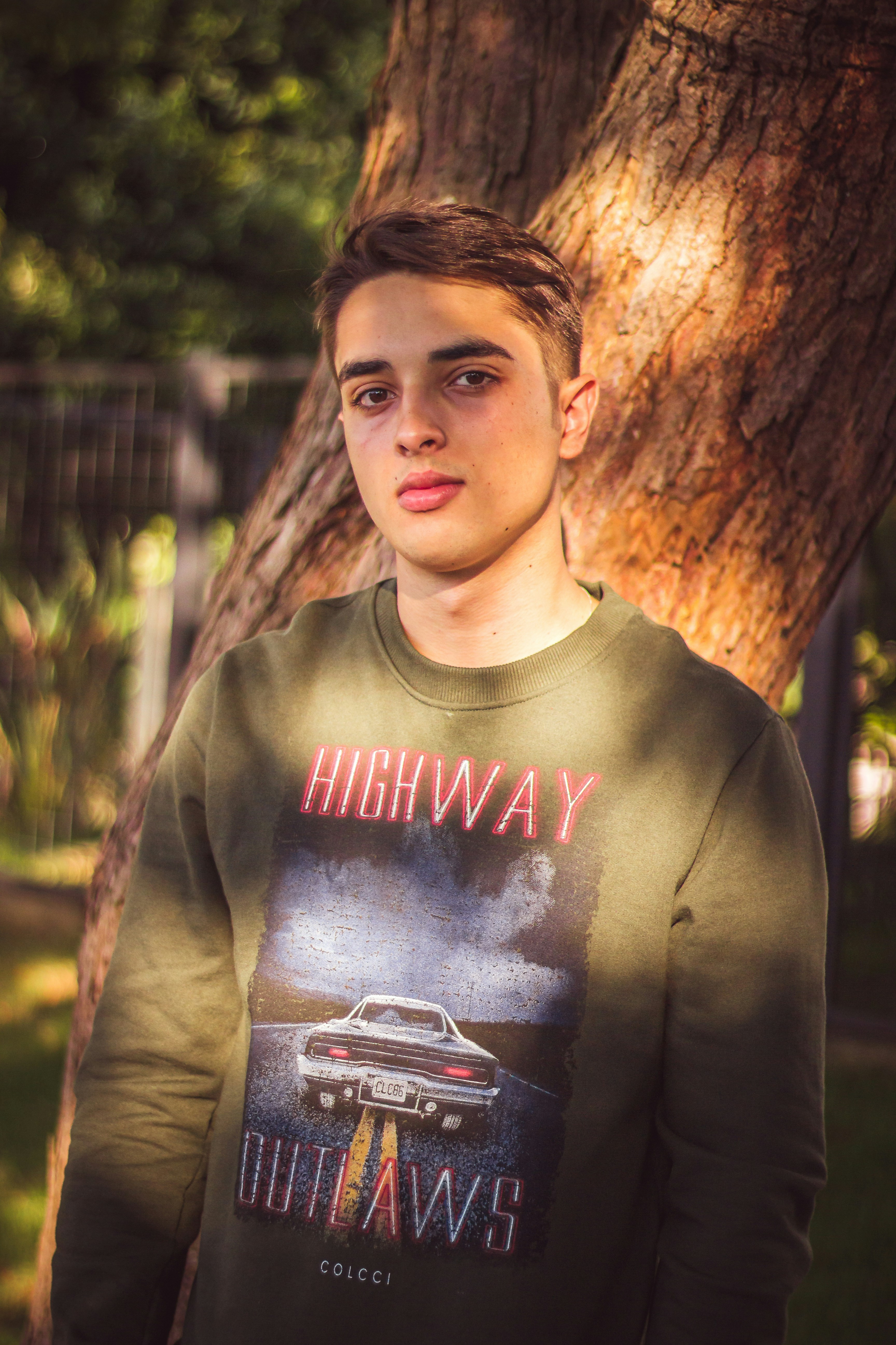 Youthful Confidence by the Trunk: A Portrait in Warm Light