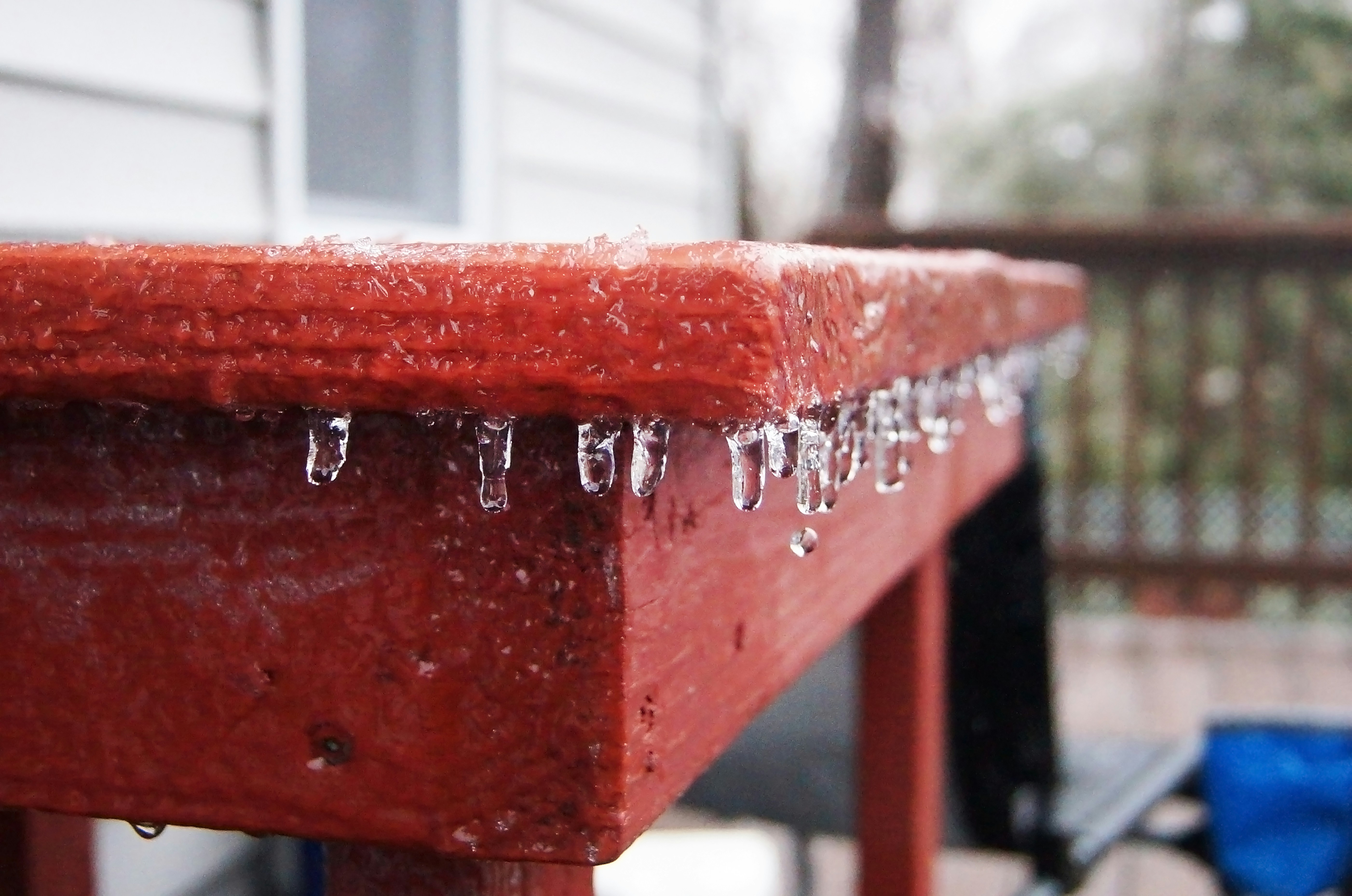 Icicles on a Rain-Dusted Red Table Edge
