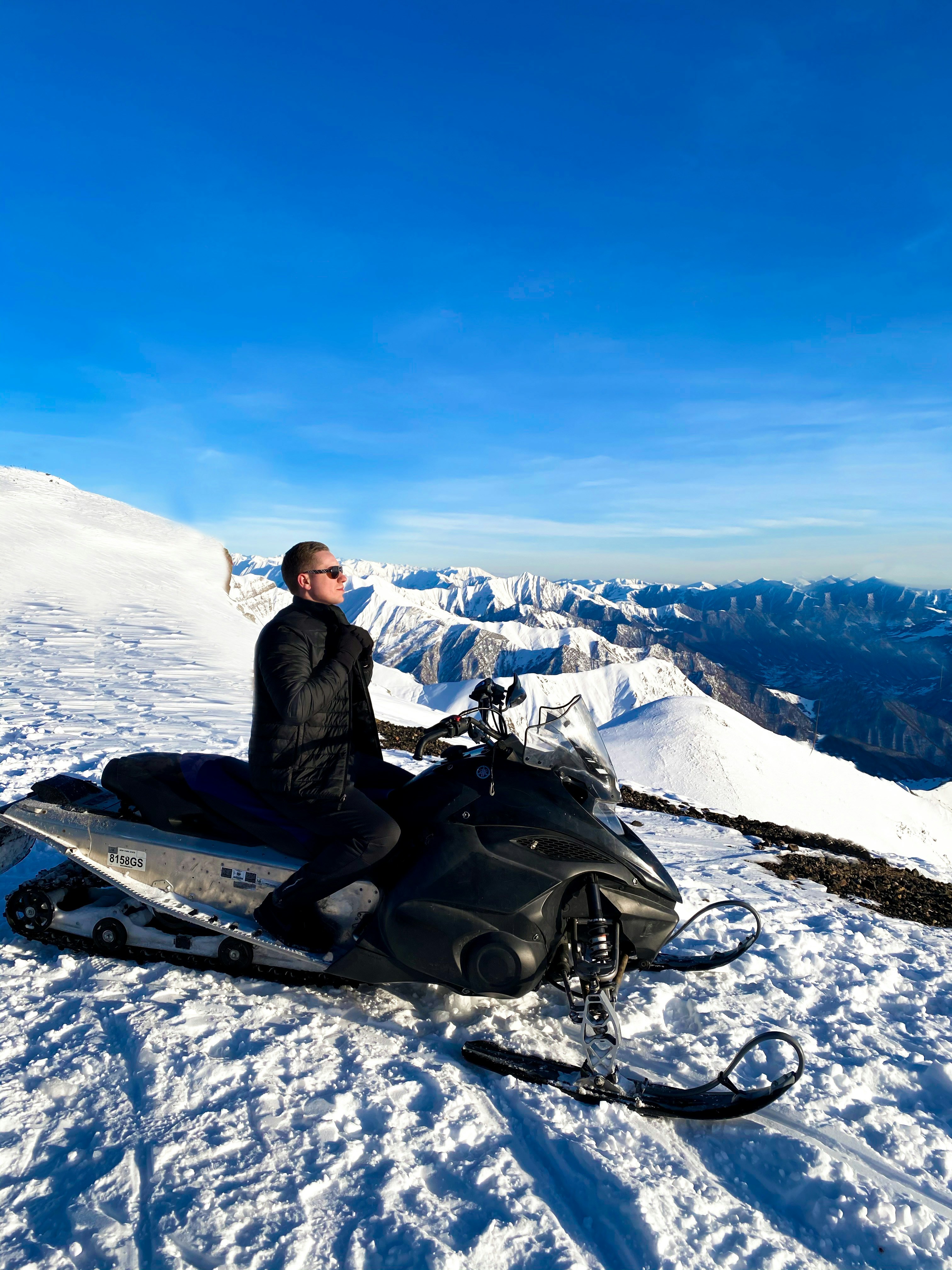 Edge of the World: Snowmobile Rider on a Snow-Covered Alpine Crest
