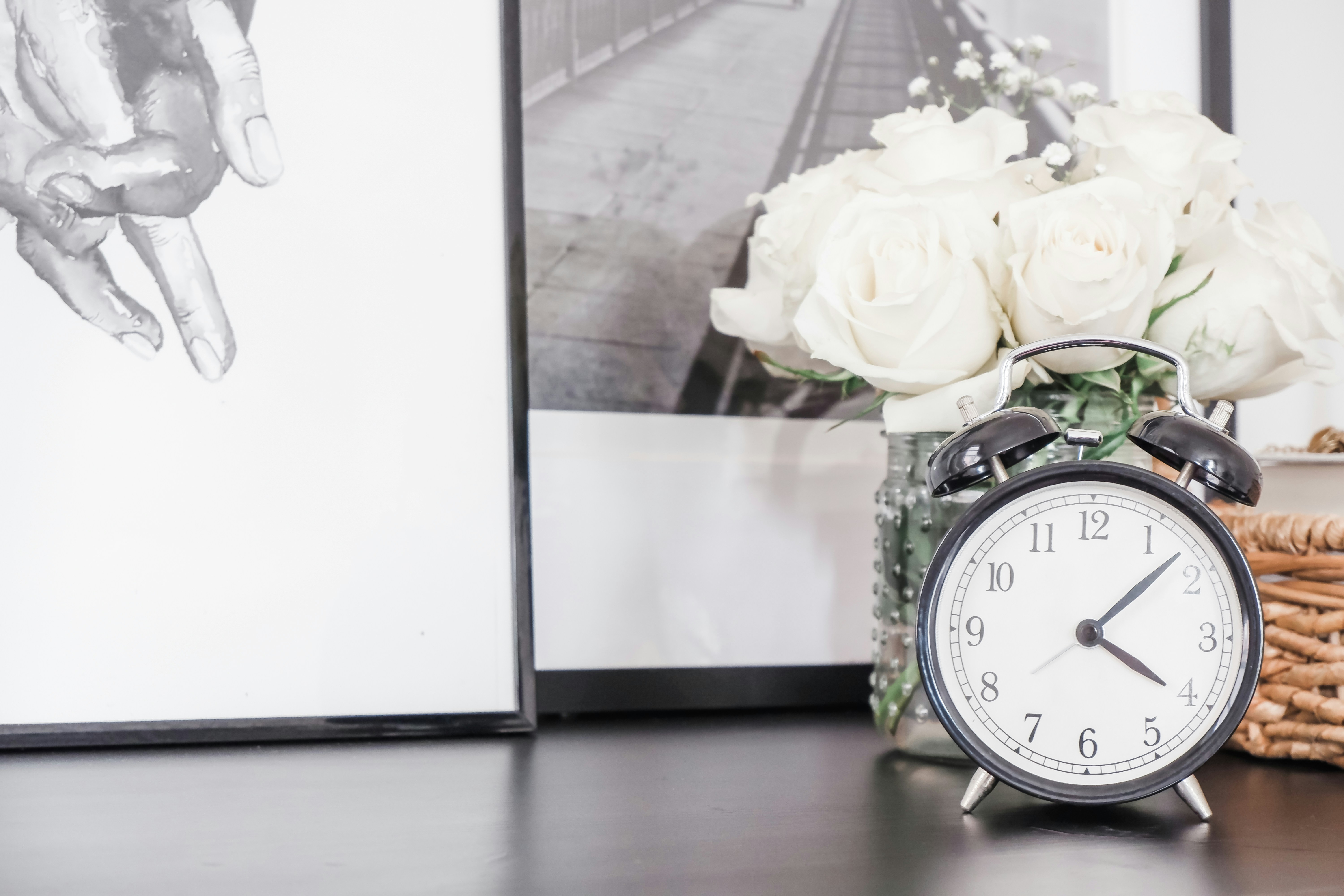 Analog Clock Among White Roses: A Monochrome Still-Life Moment