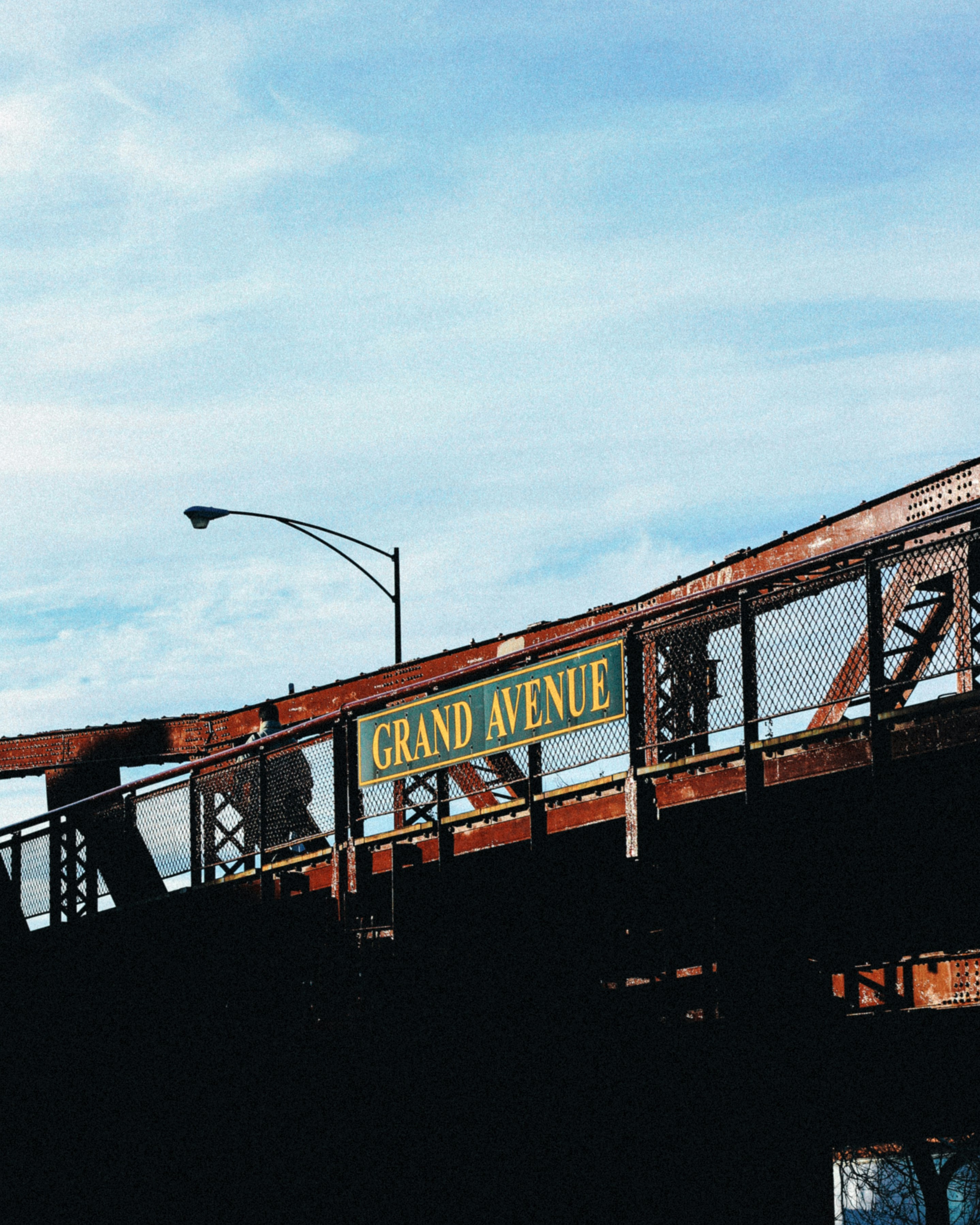 Grand Avenue Sign Over a Weathered Bridge Against a Cerulean Sky
