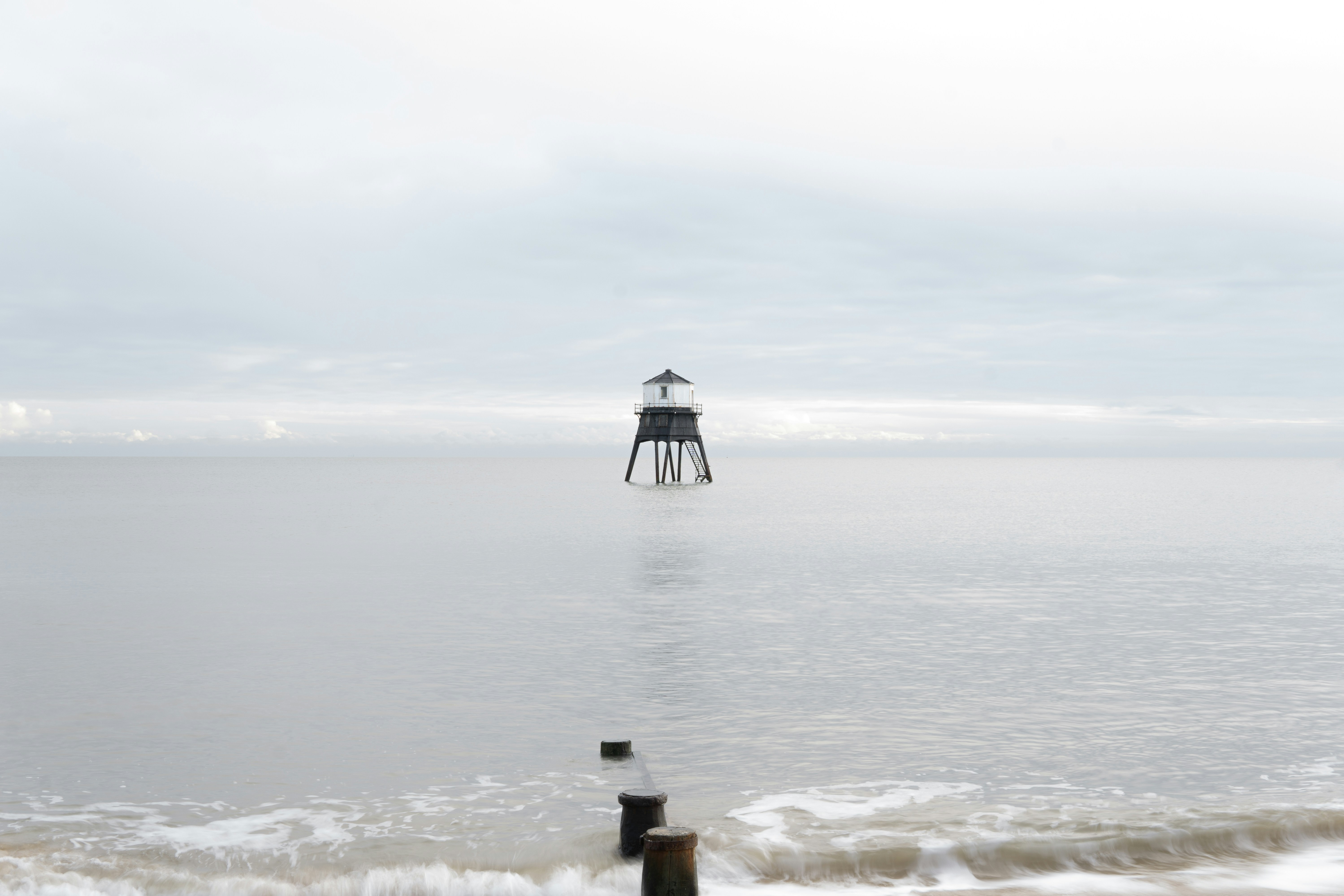 Solitary Beacon on a Glassy Sea Horizon