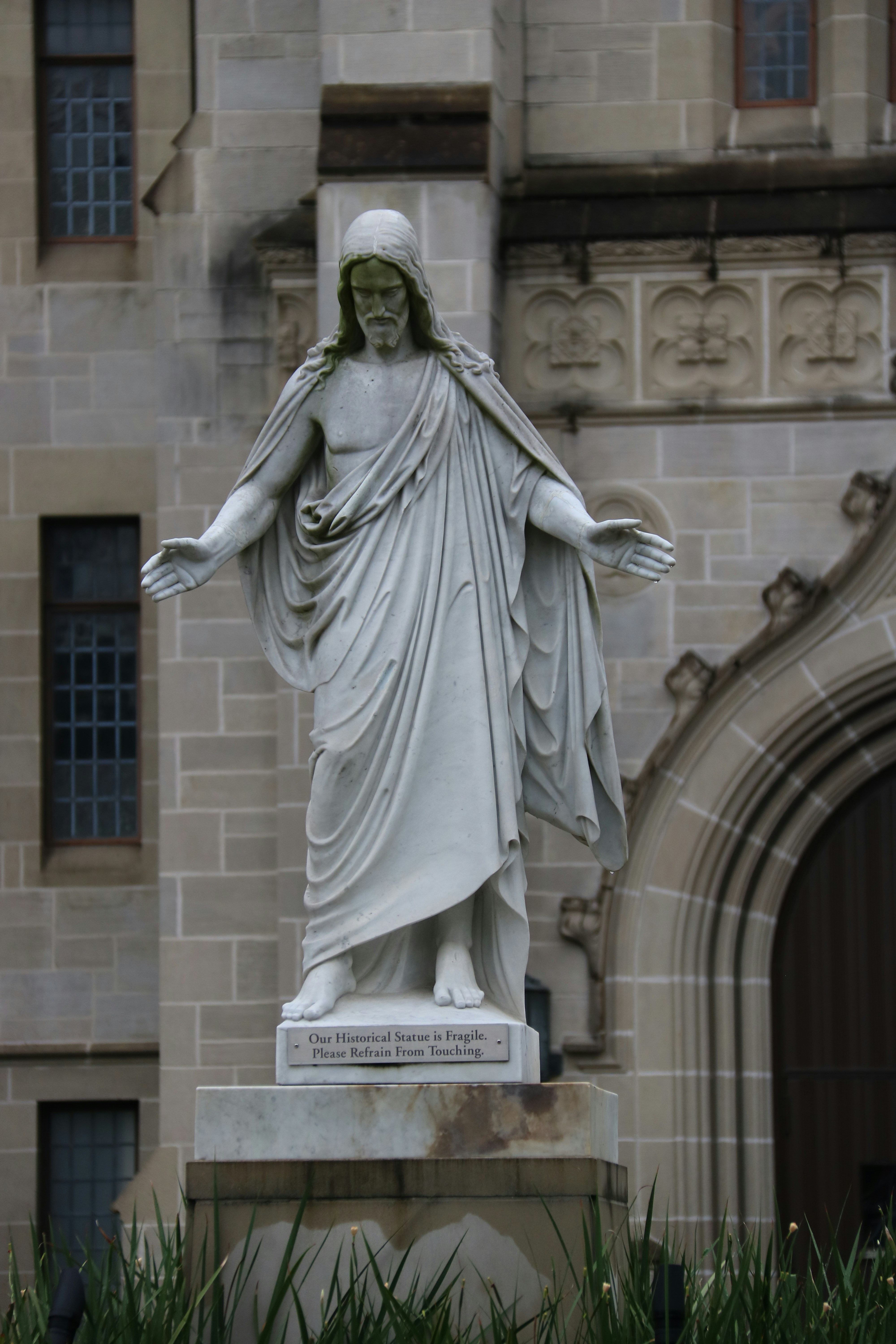 Outstretched Mercy: Marble Christus Against a Carved Facade
