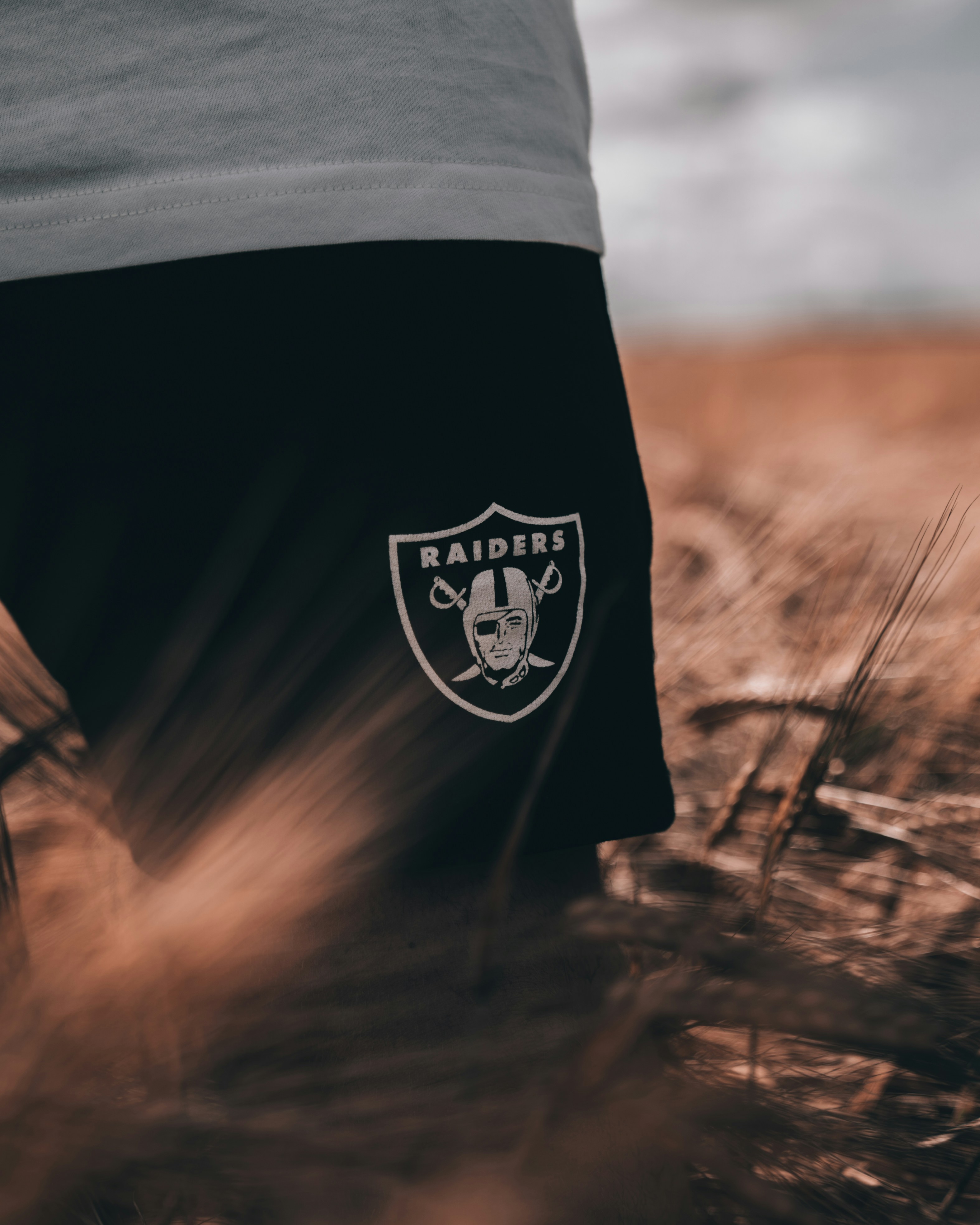 person in black and white shirt standing on brown grass field during daytime
