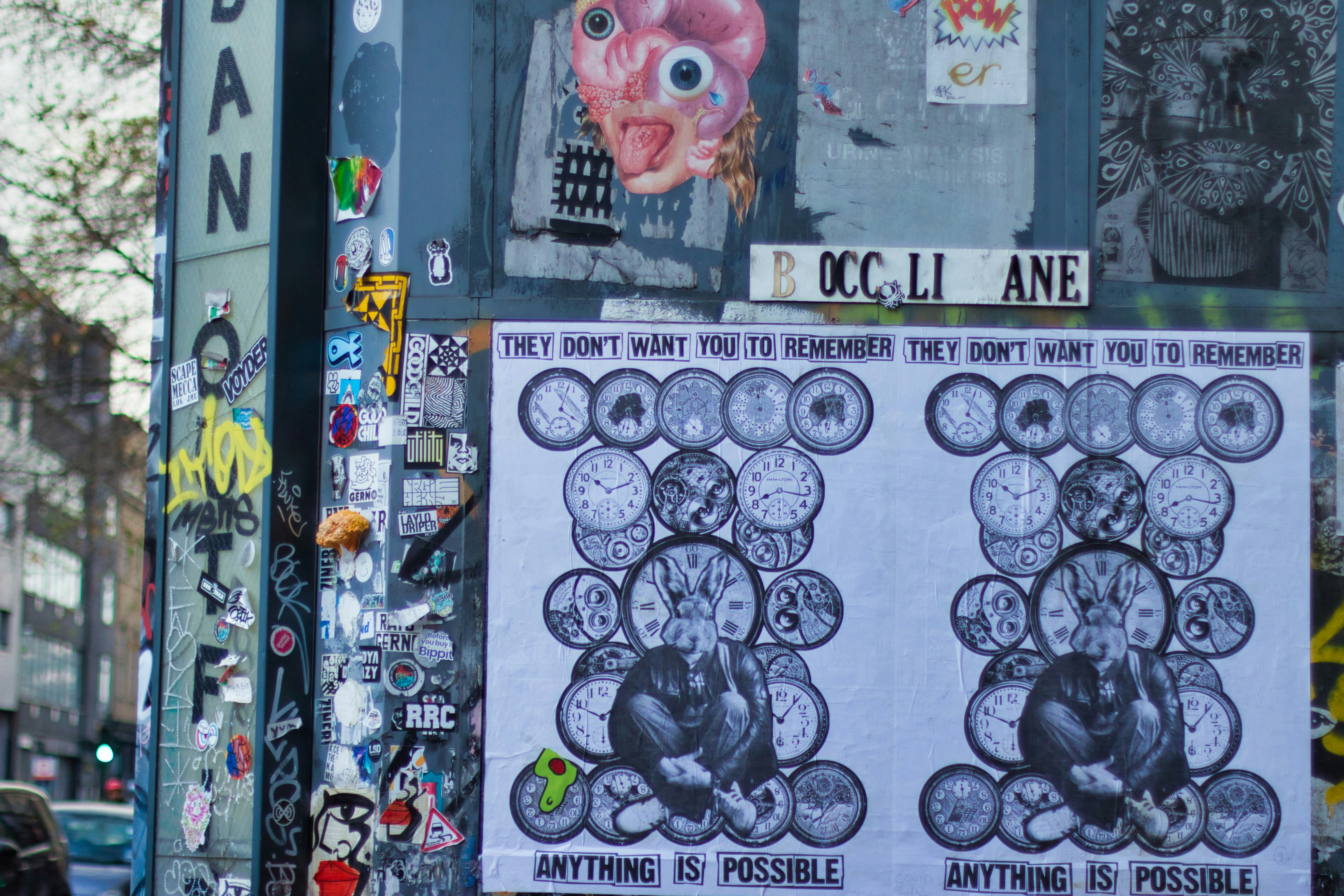 Stickered Corner: A Collage of Street Murals and Graffiti Overlays