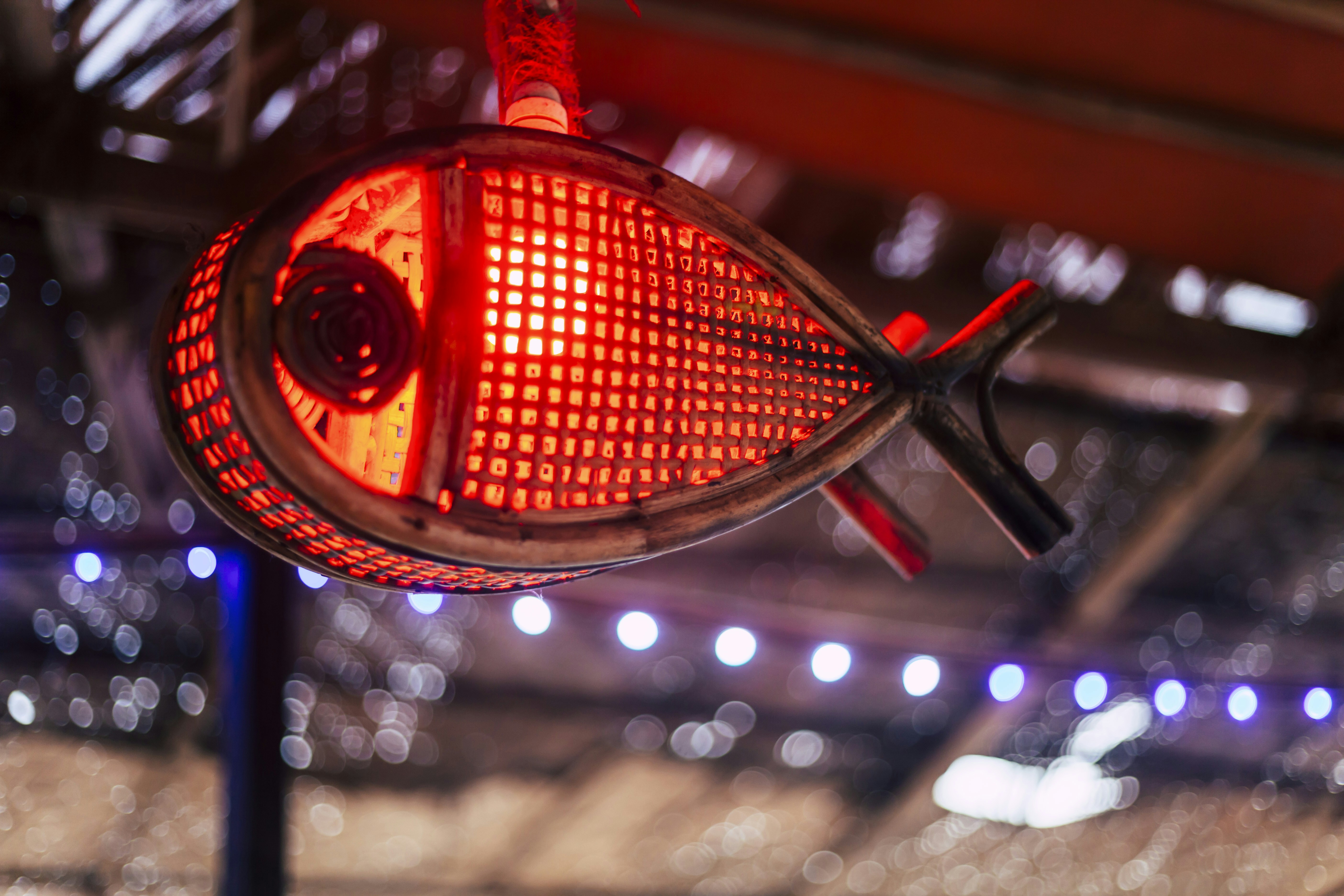 Gridfish Glow: A Crimson Pendant Lamp Under a Sky of Bokeh