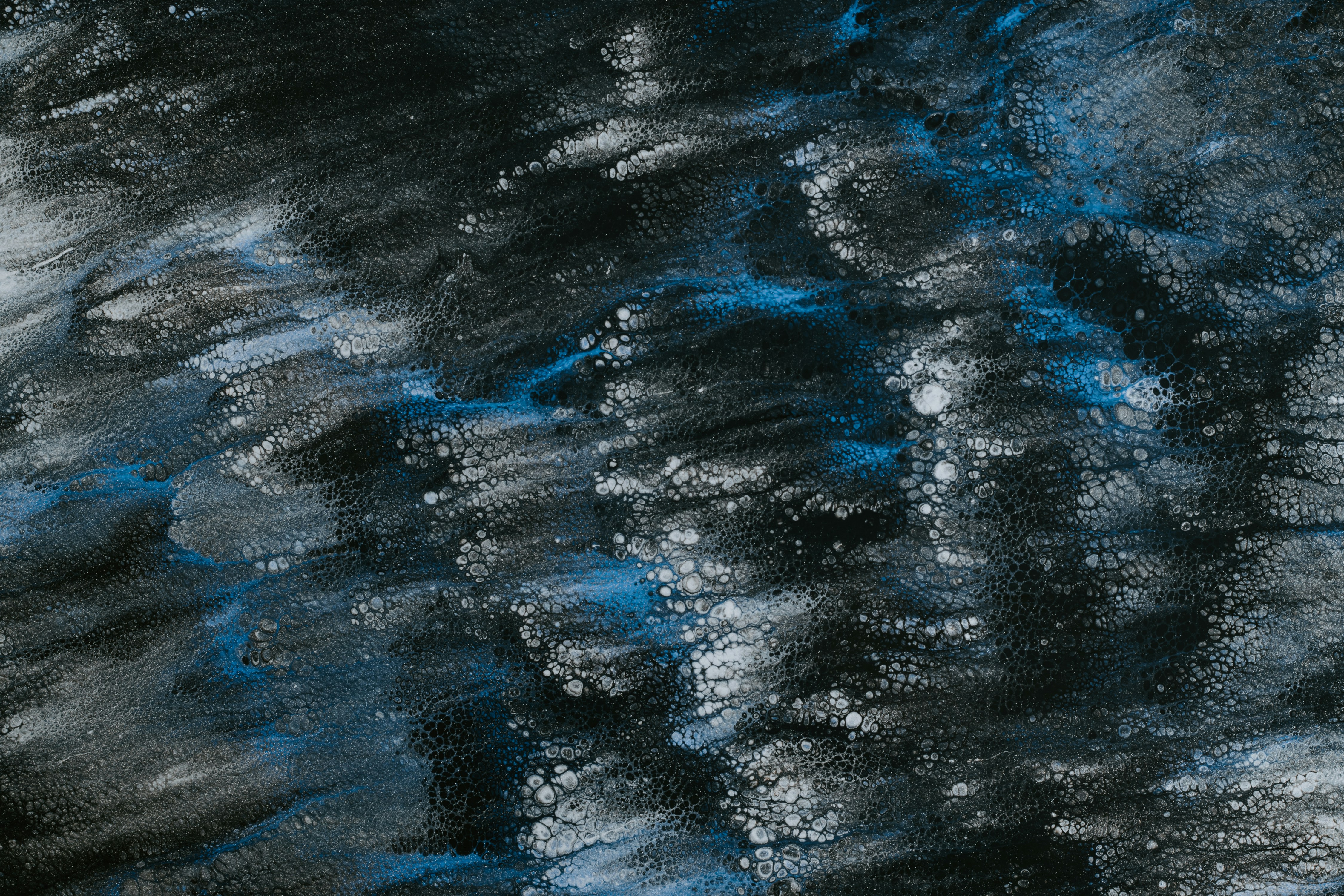 Abstract painting featuring swirling patterns of black, blue, and white, evoking a sense of movement and depth.
