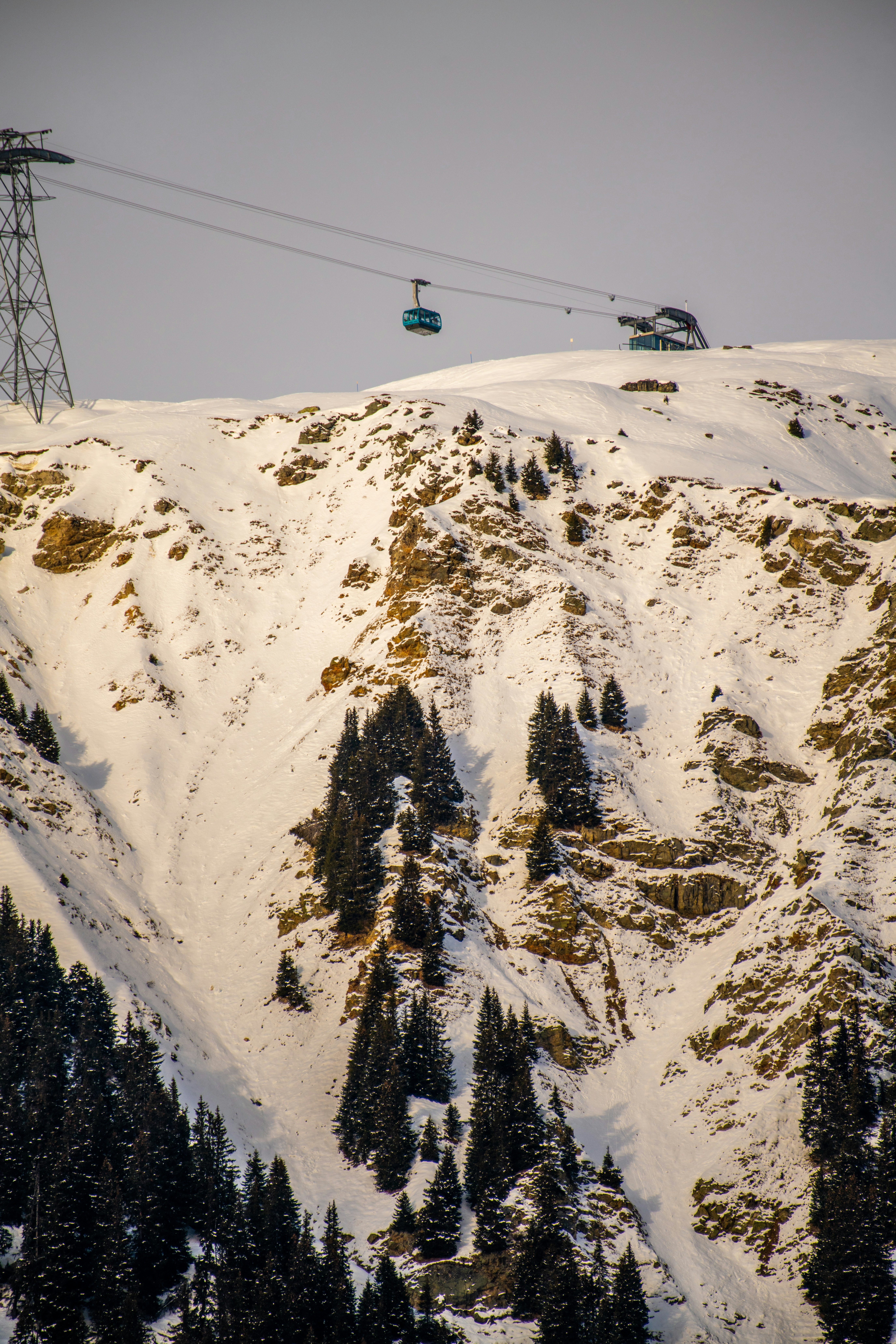 Blue Gondola Crossing the Snow-Blanketed Alpine Ridge