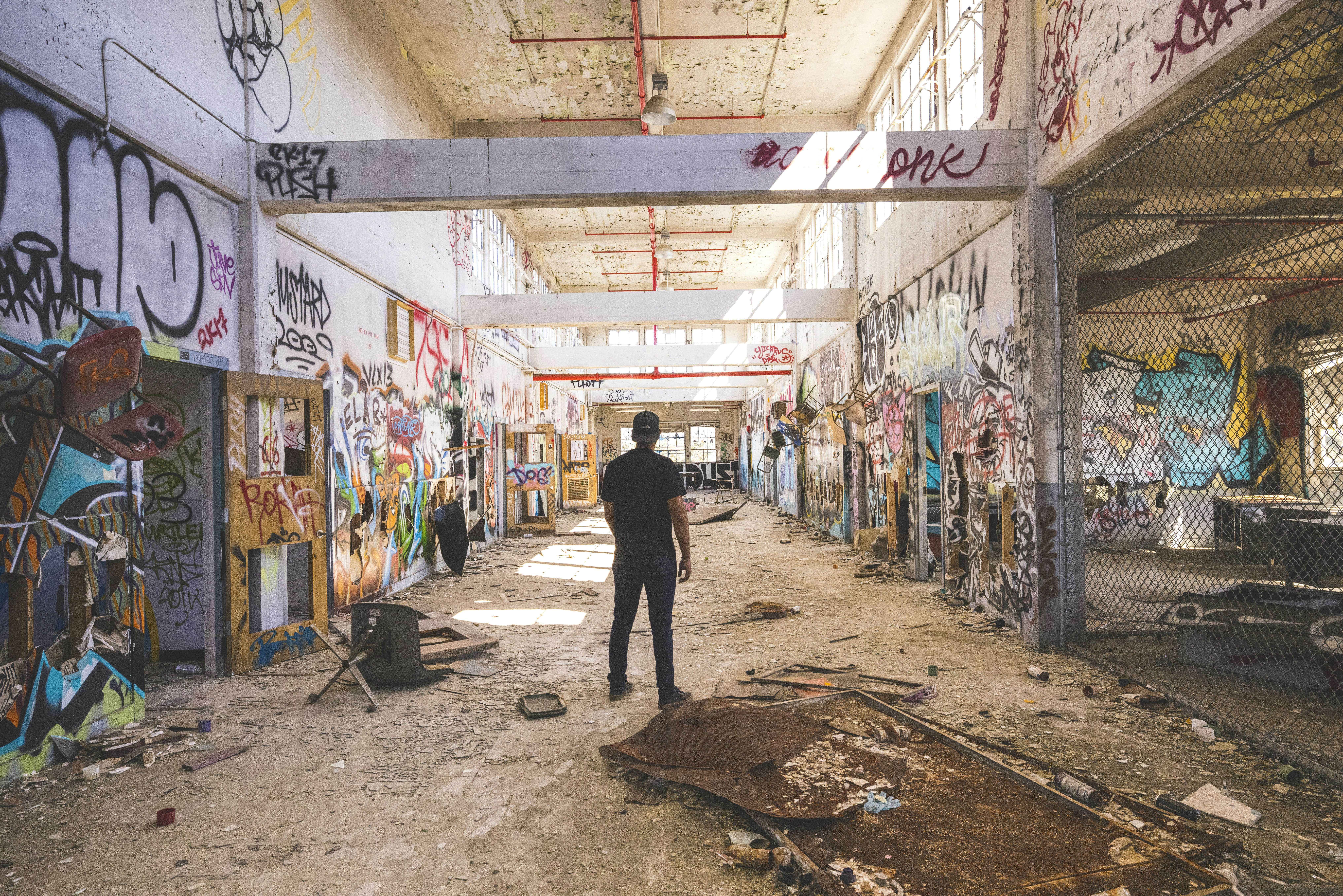 Center of Decay: A Lone Figure Amid Graffitied Halls