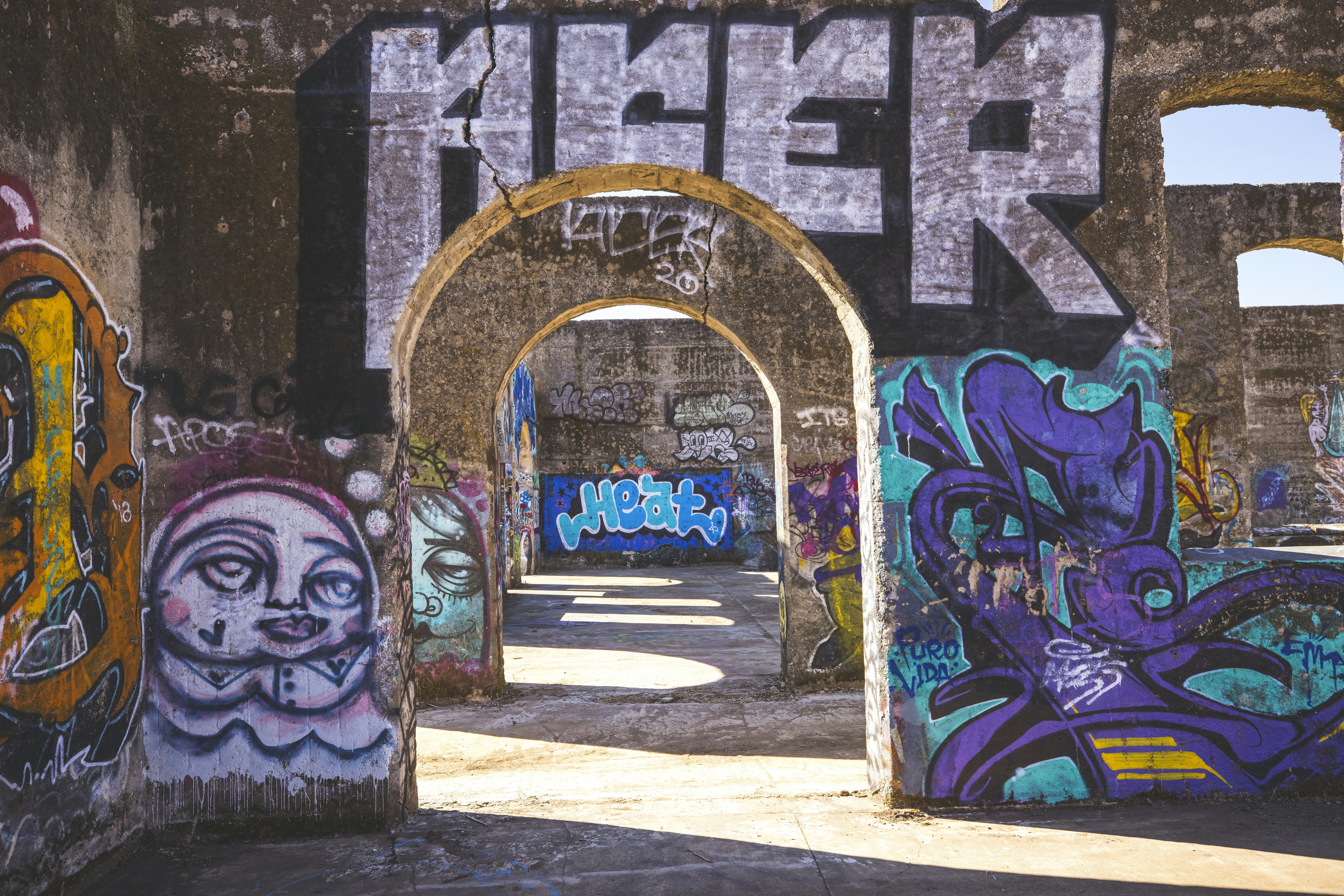 Archway Odyssey: Sunlit Corridor Through a Graffiti Gallery