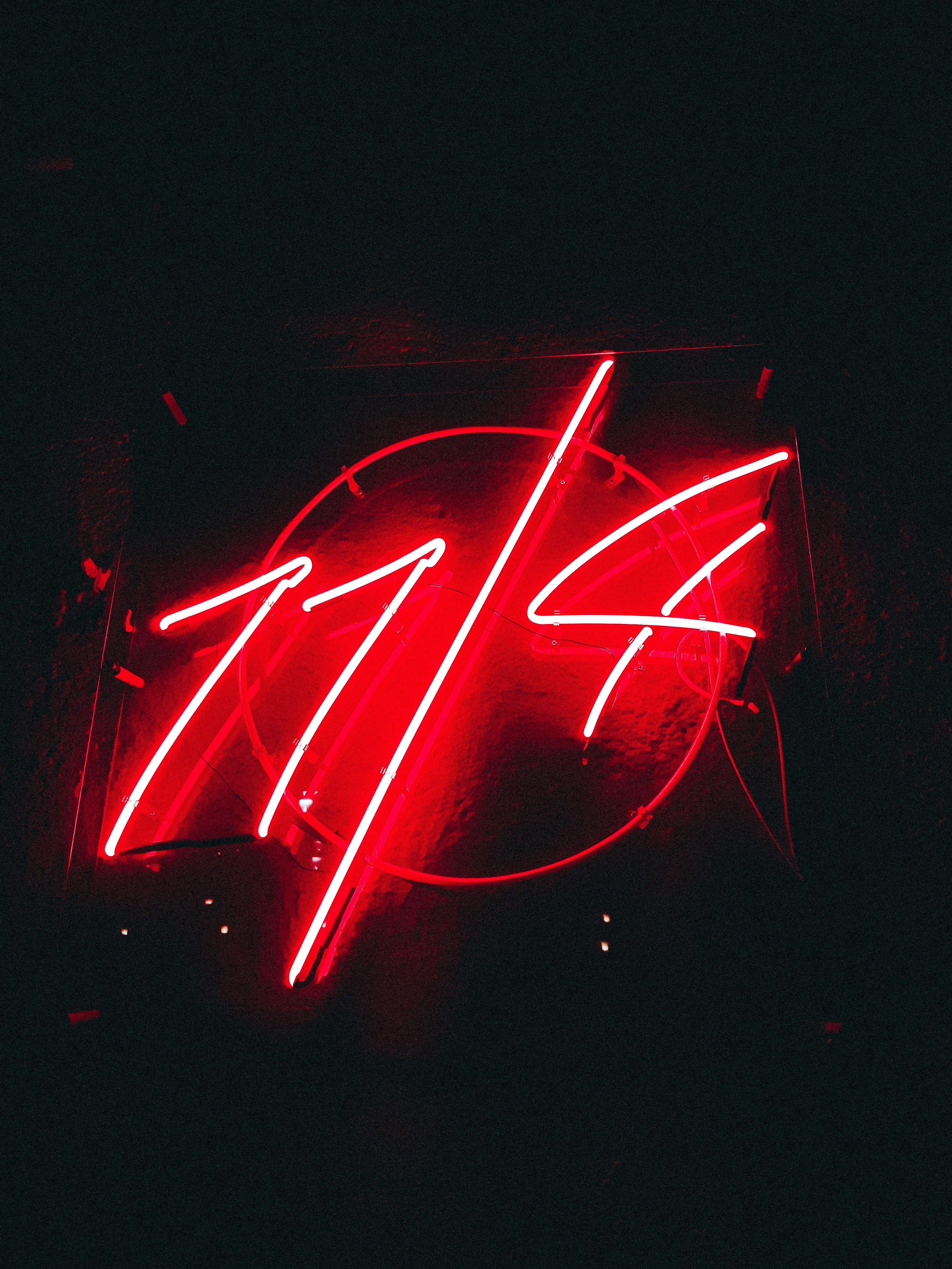 Illuminated neon sign displaying the numbers 11/4 against a dark backdrop, creating a striking contrast.