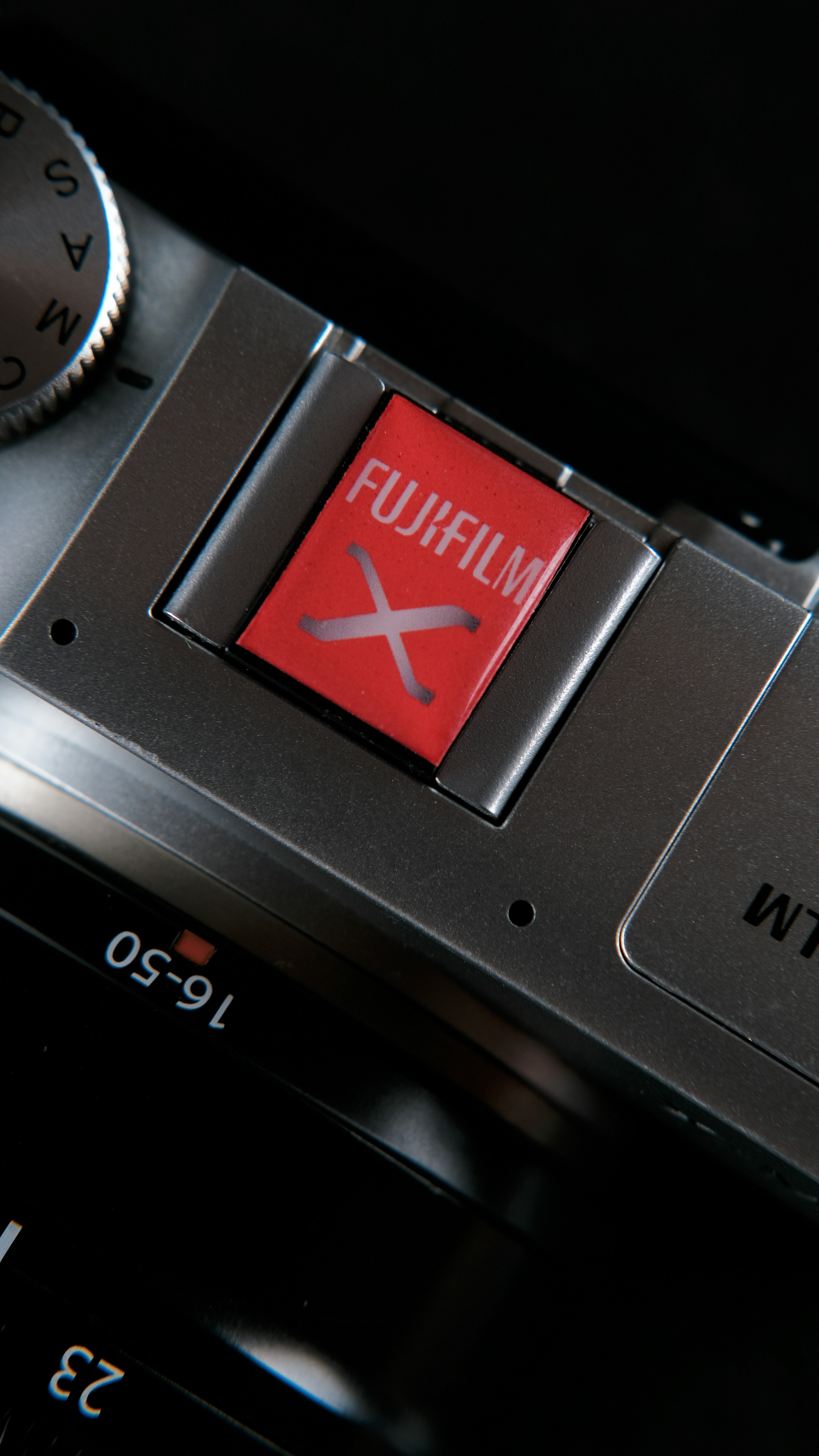 Camera Fujifilm X-M1 with red hot shoe cover.