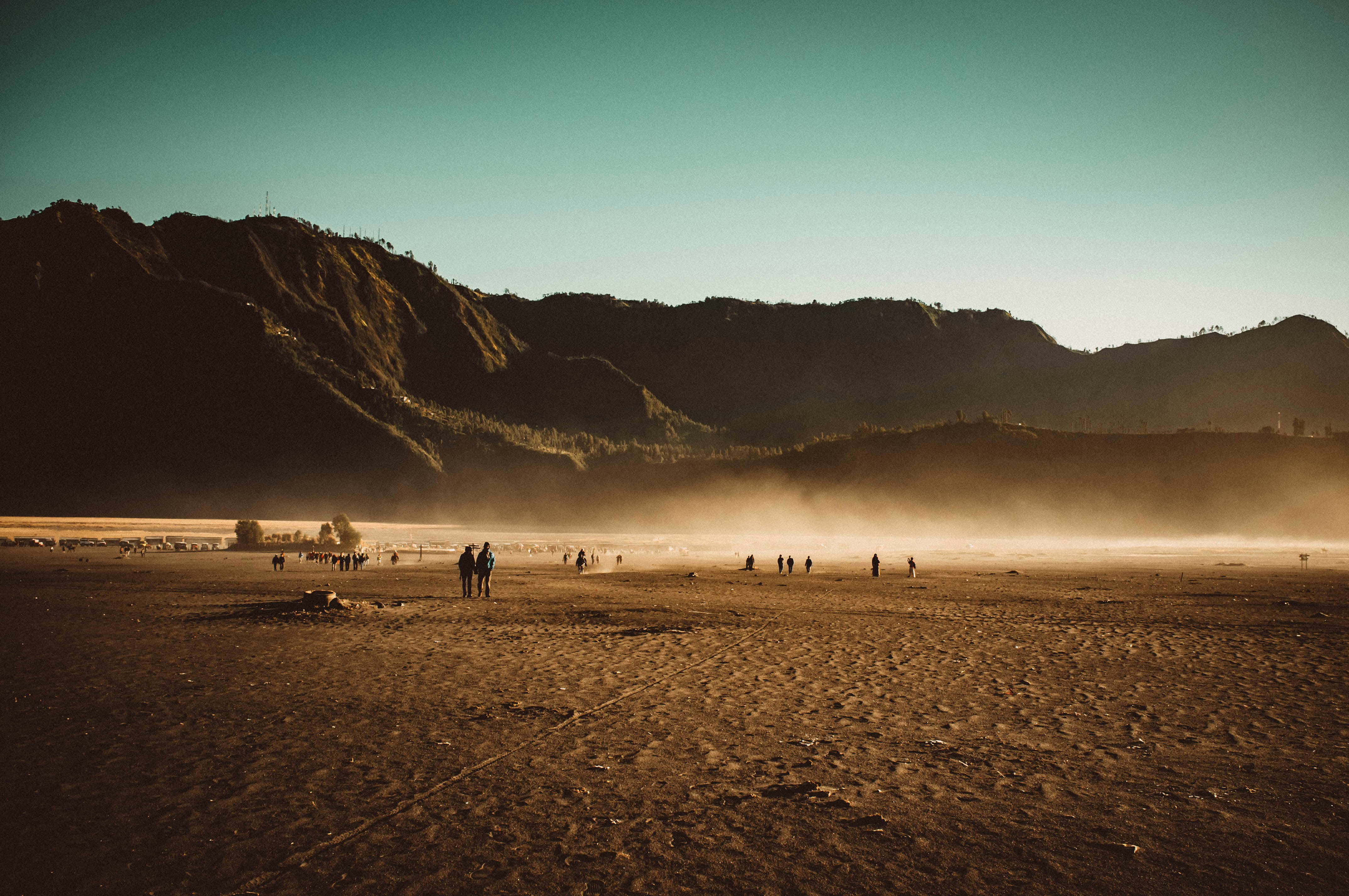 Early morning light casts a golden glow over Mount Bromo's vast desert landscape.