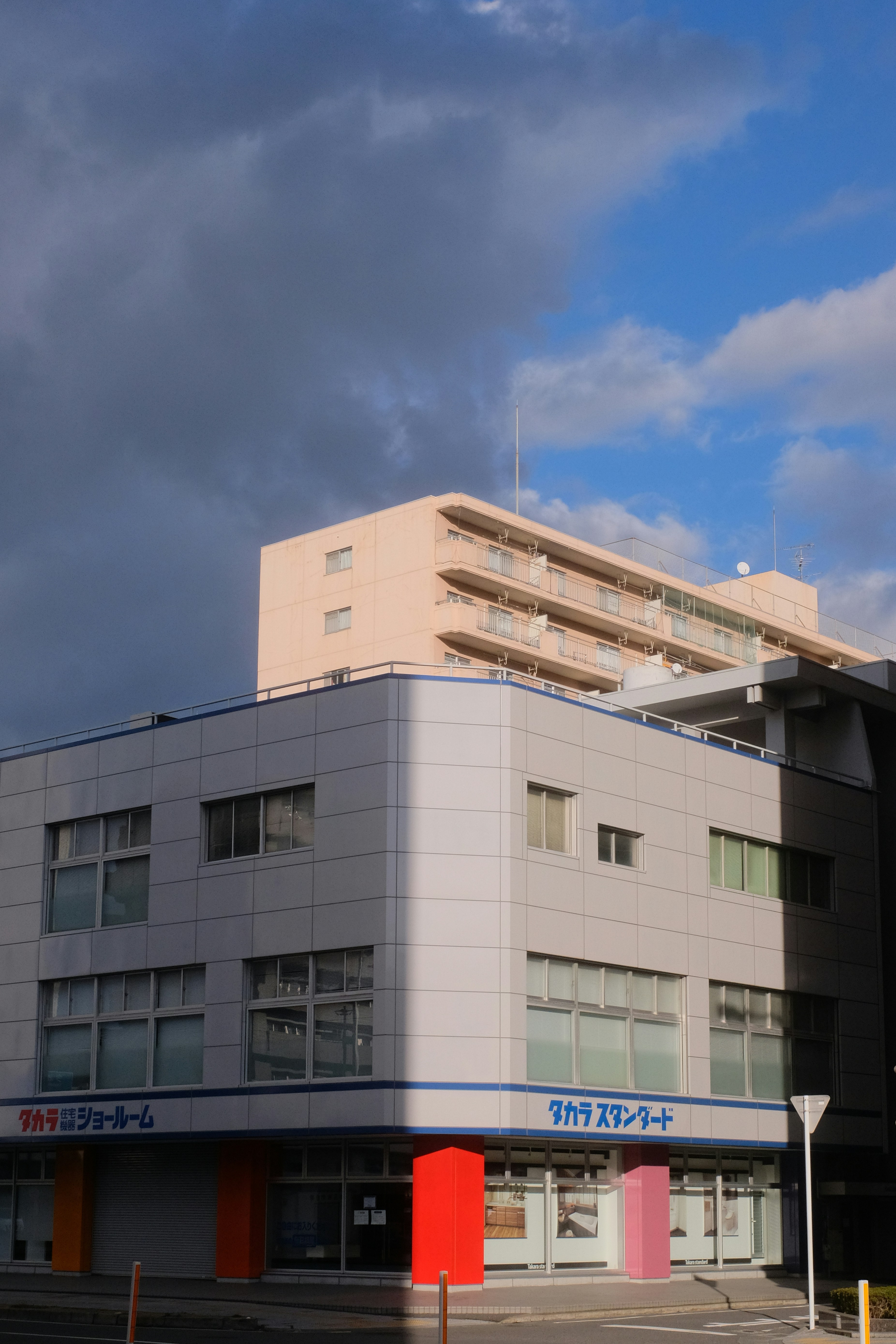 Modern architectural structure with contrasting light and shadow, showcasing a blend of colors on the facade.