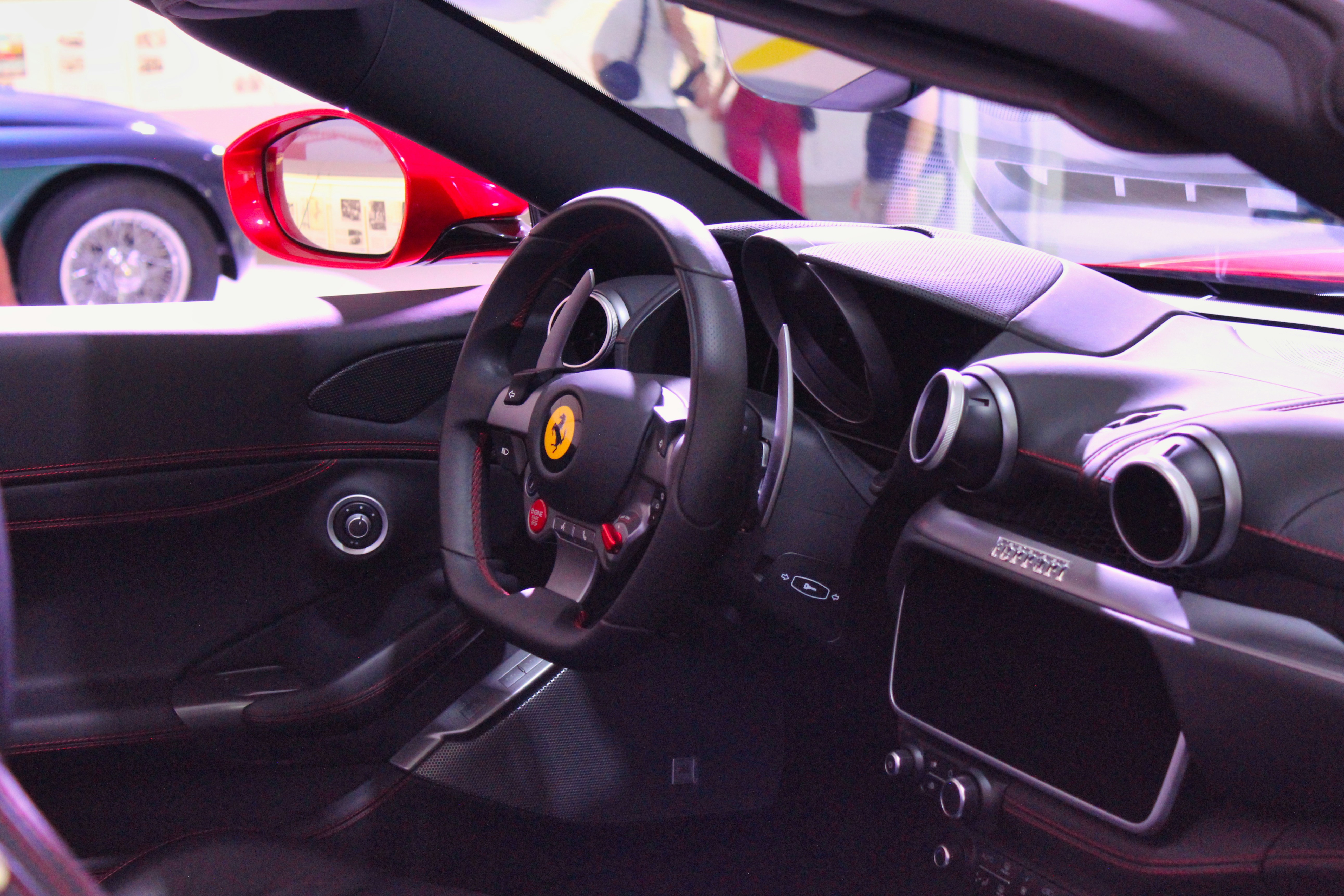 Ferrari Cockpit Glow: Leather-Wrapped Steering Wheel and Prancing Emblem in Focus