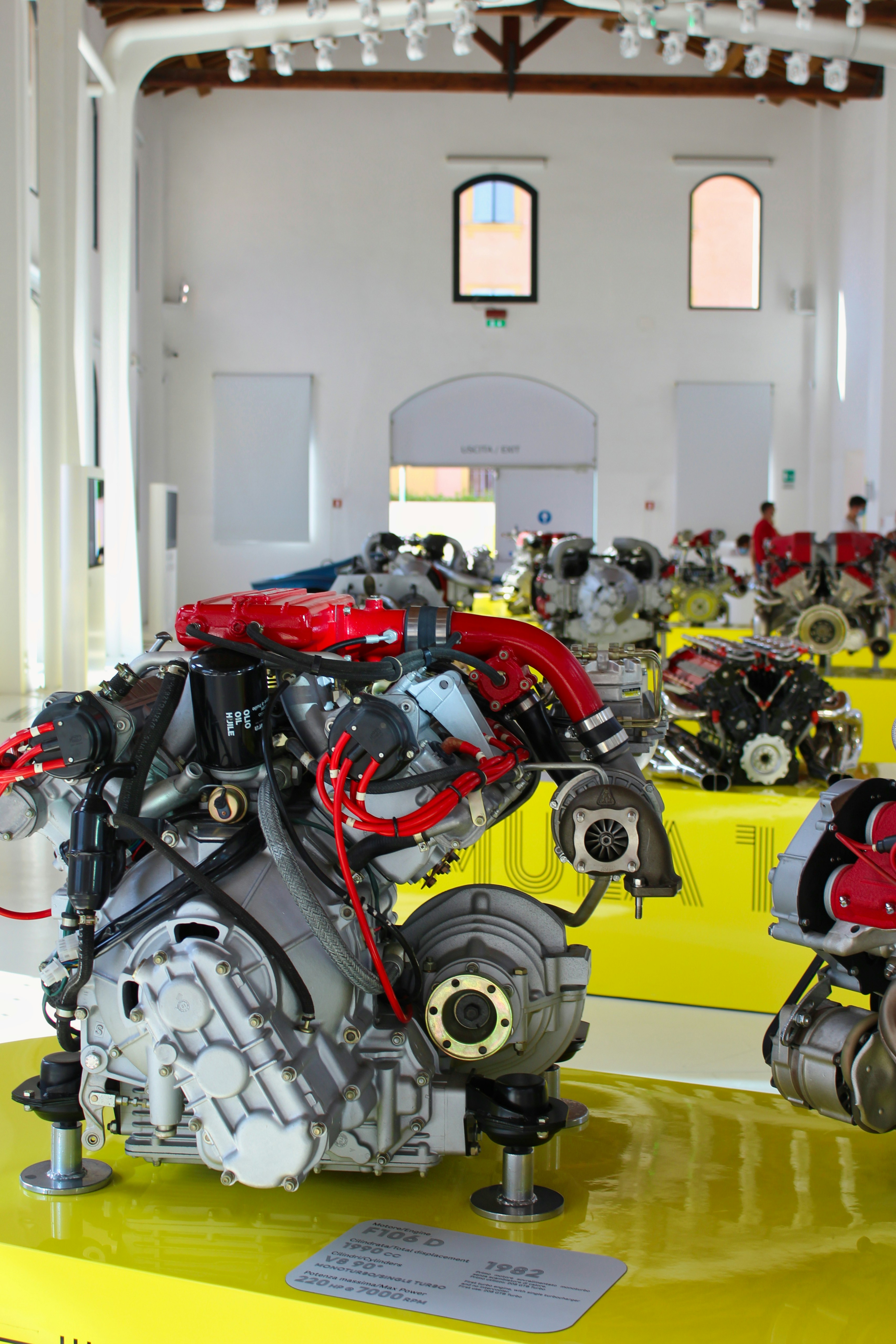 Chrome and Levers: Engines on Lemon-Yellow Pedestals in a Bright Exhibition