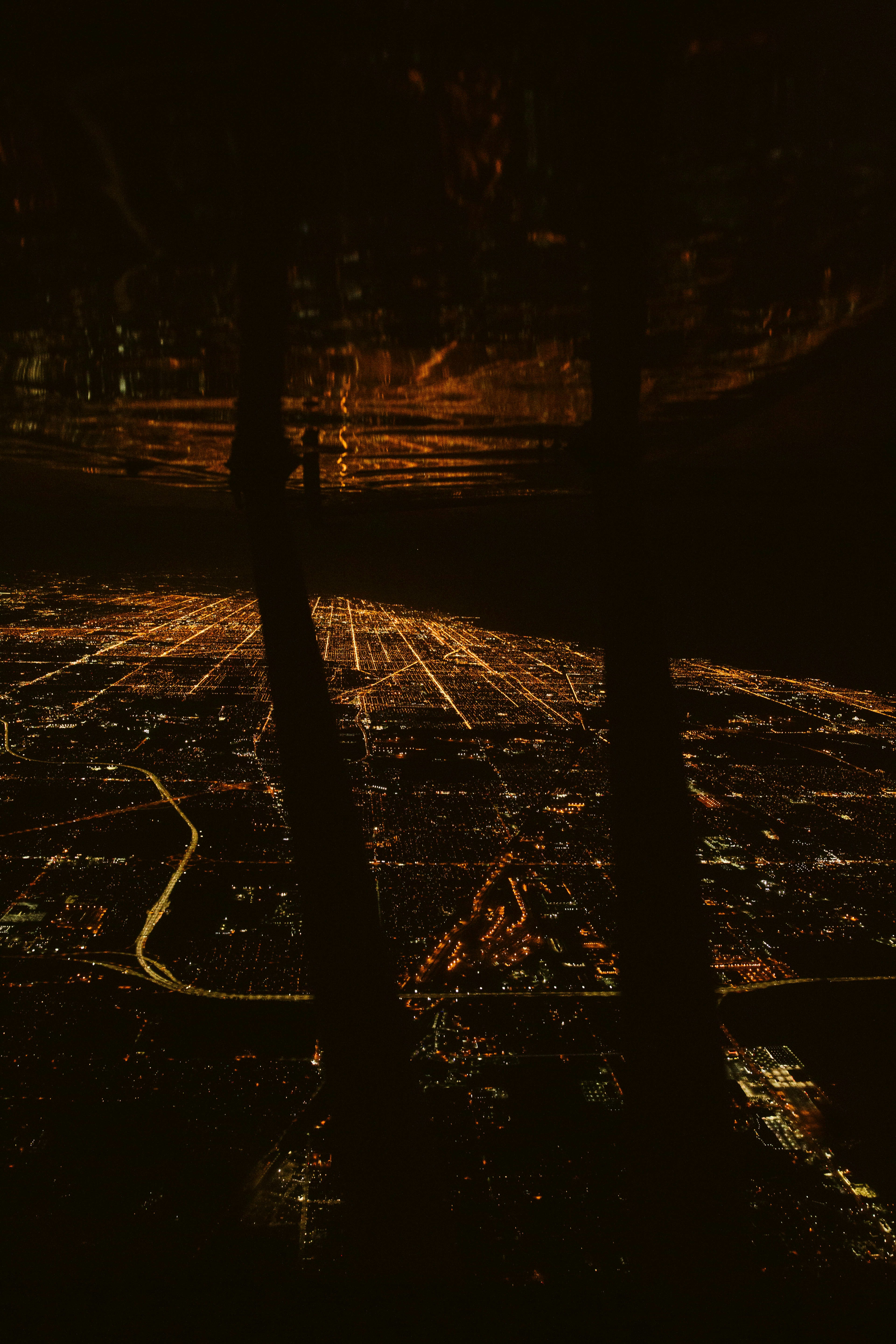 Aerial view of a sprawling city illuminated at night, showcasing a grid of vibrant lights against a dark backdrop.