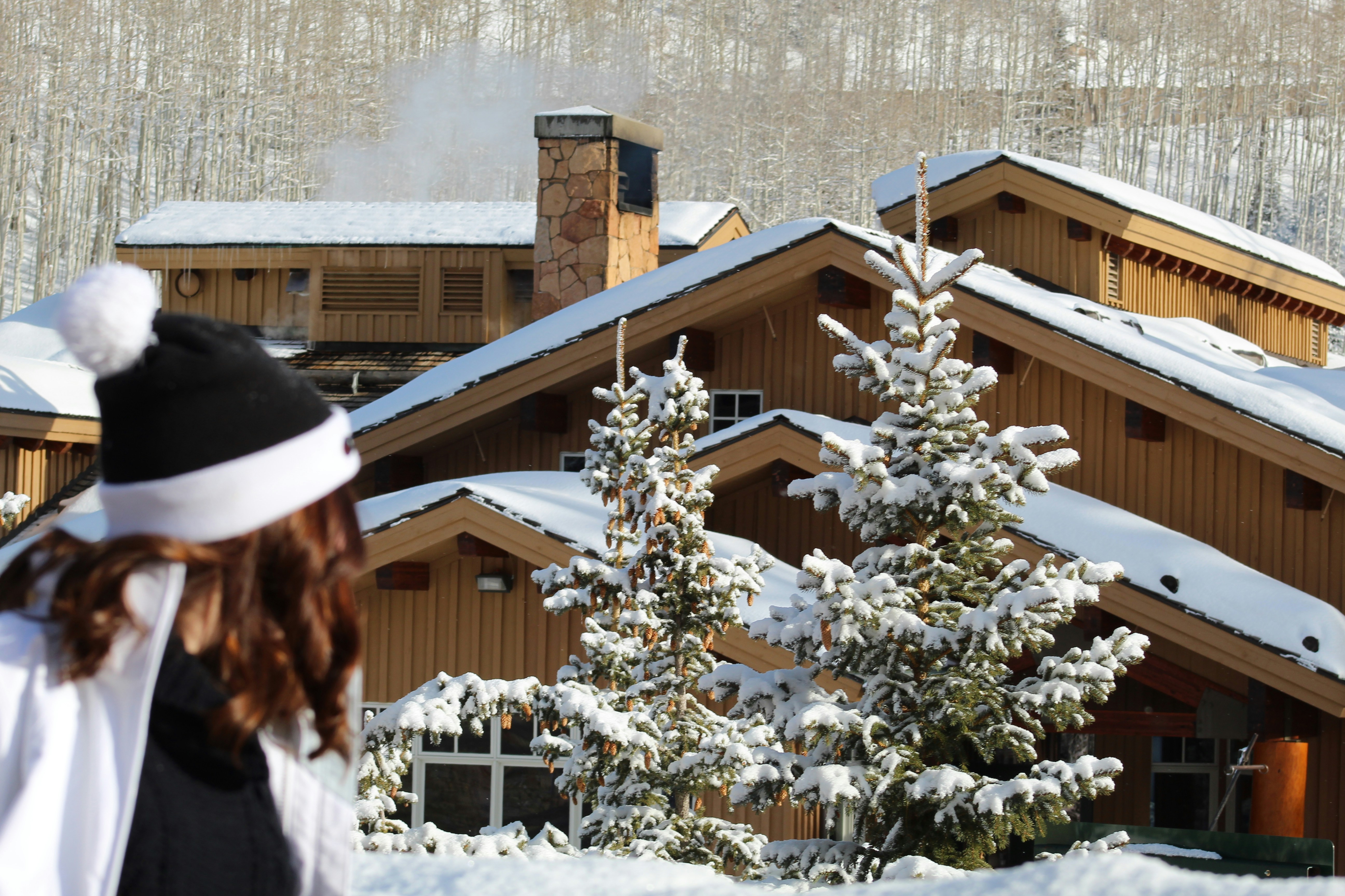 Girl standing in front of snow covered house.