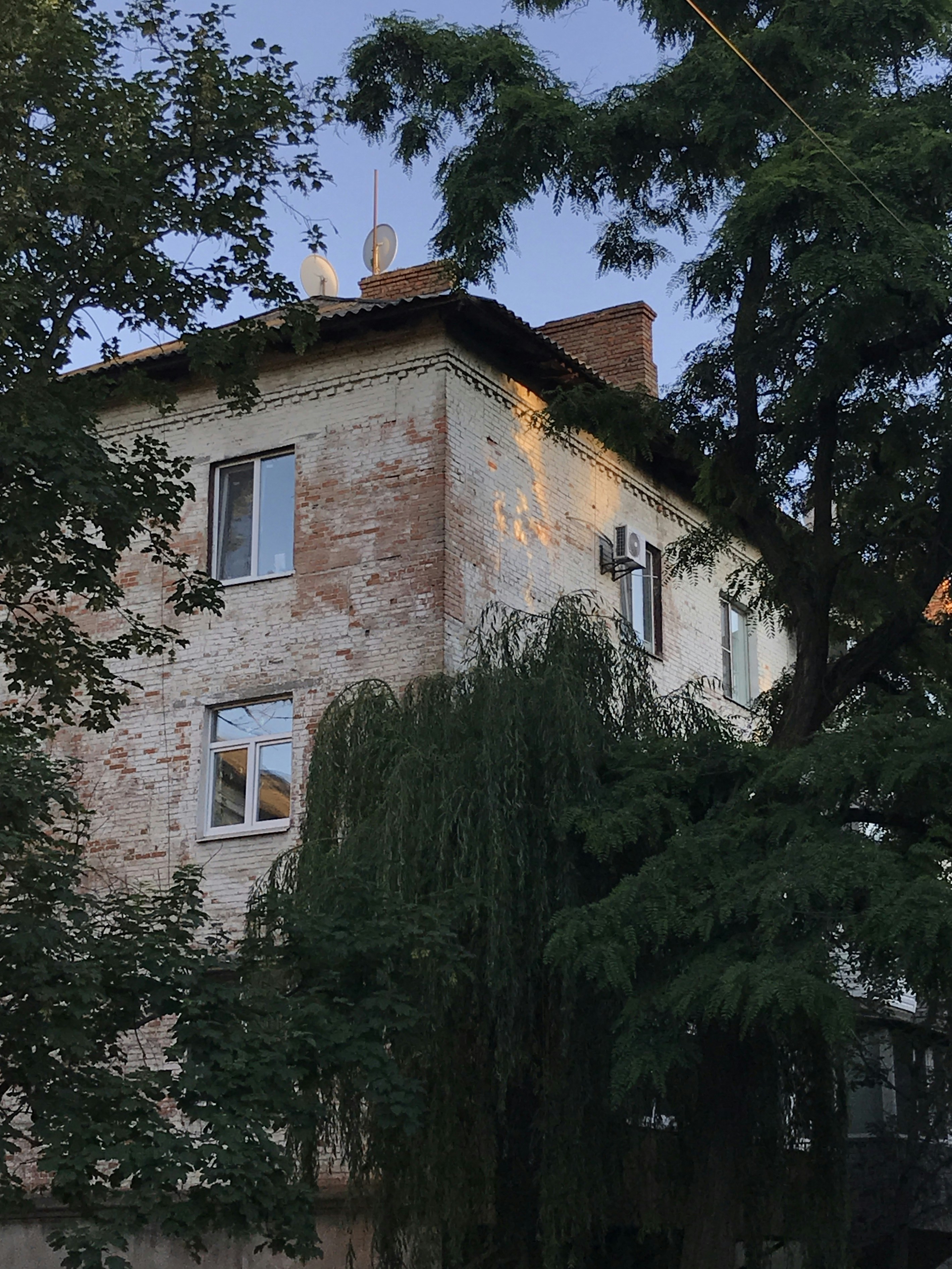 brown concrete building near green trees during daytime