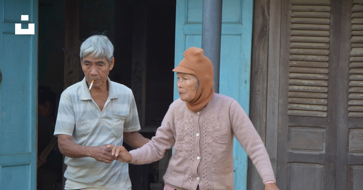 흰색과 검은색 꽃무늬 드레스를 입은 여자 옆에 서 있는 파란색 드레스 셔츠를 입은 남자 사진 Unsplash의 무료 여자 이미지